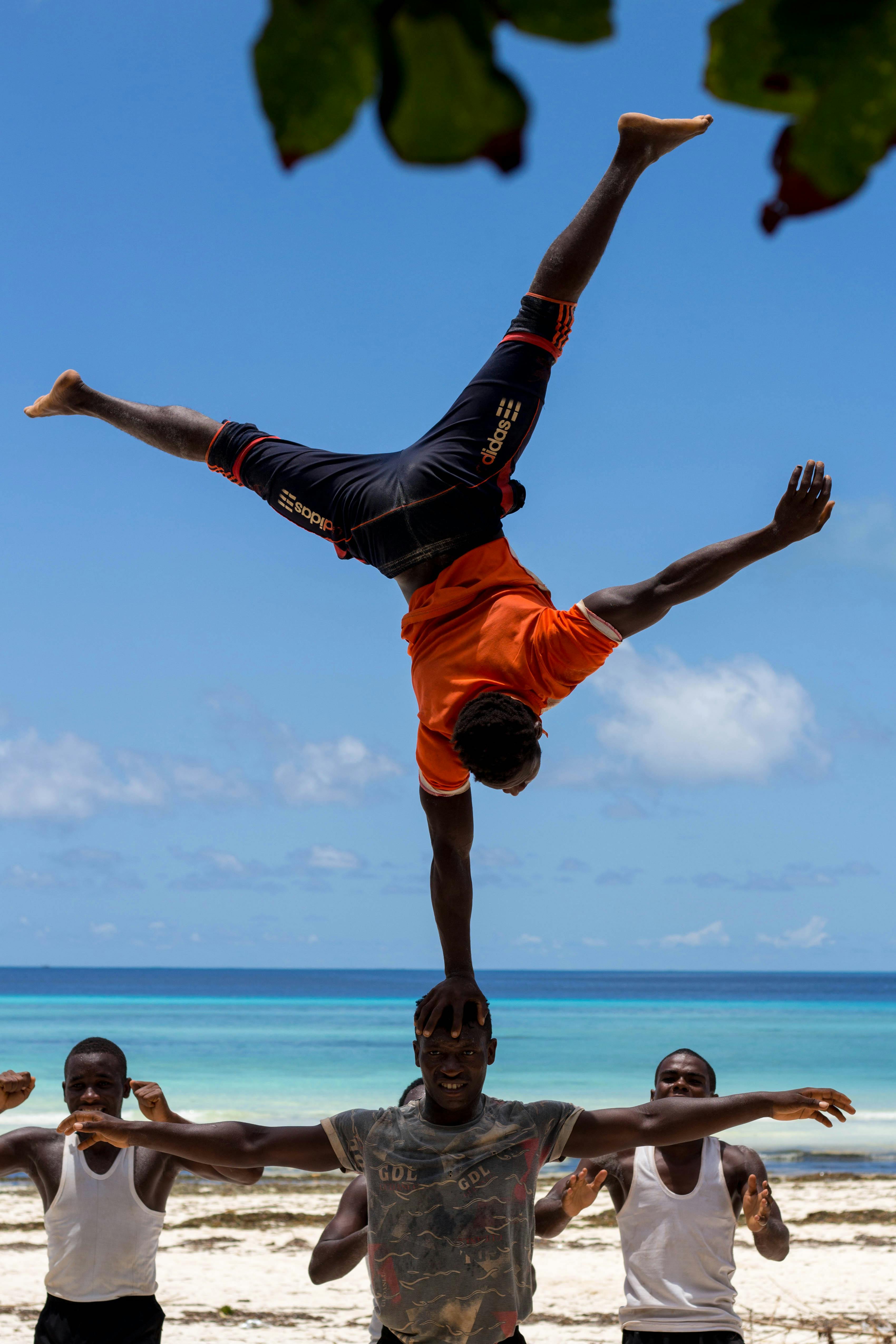 Man Standing on One Hand on Top of Another Man · Free Stock Photo