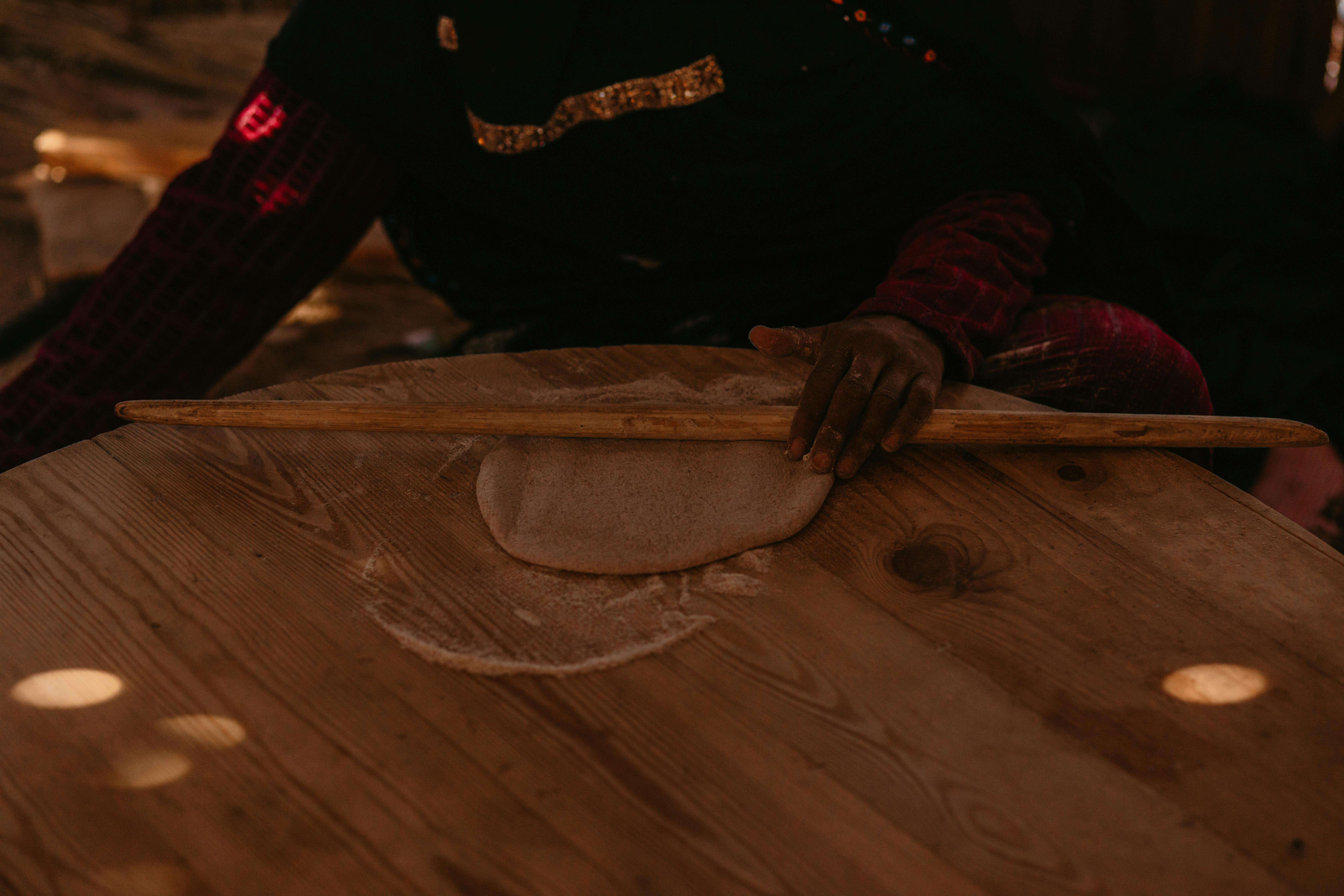 Hand Holding Roller and Rolling Dough · Free Stock Photo