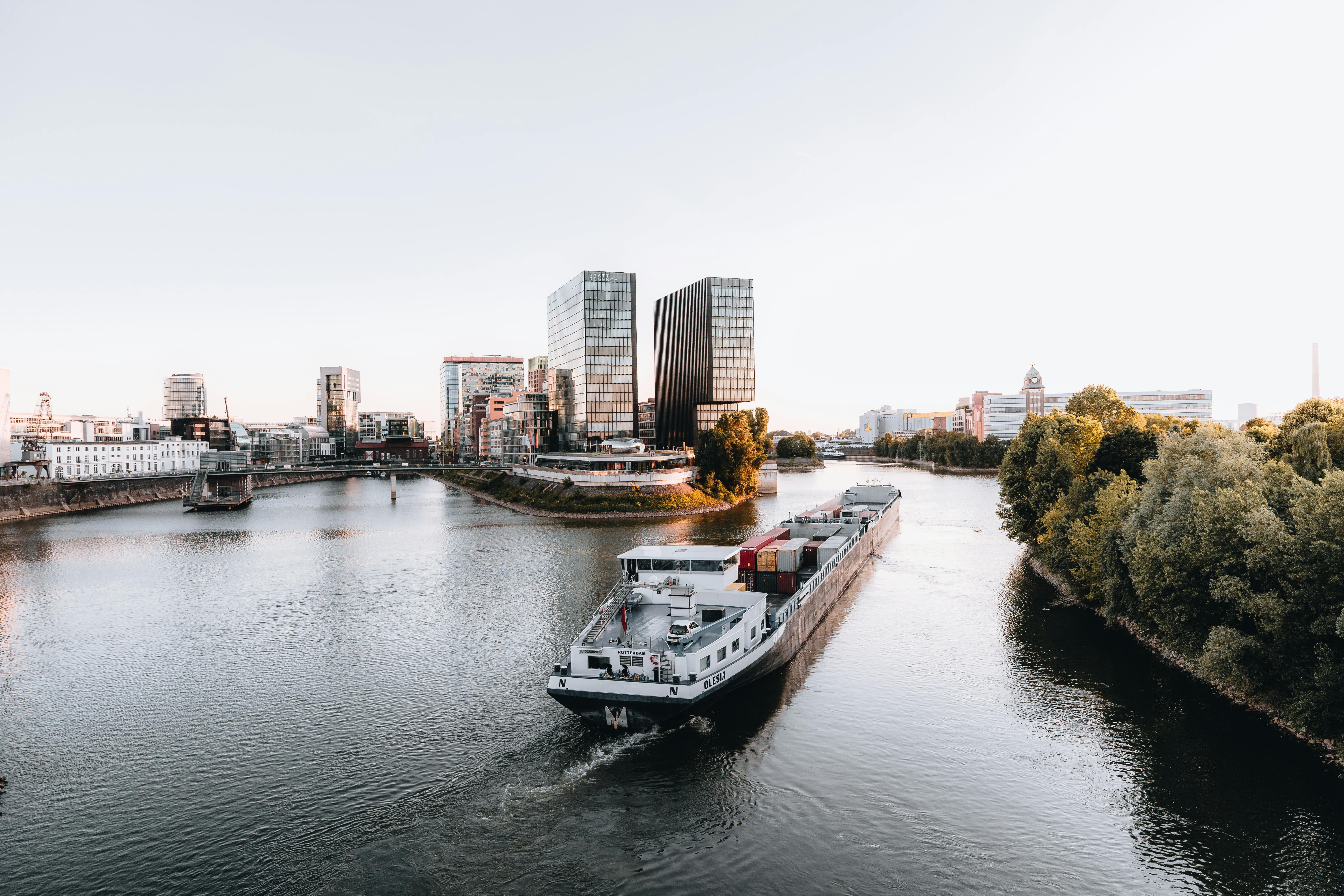 Cargo Ship Sailing against Hyatt Regency in Dusseldorf · Free Stock Photo