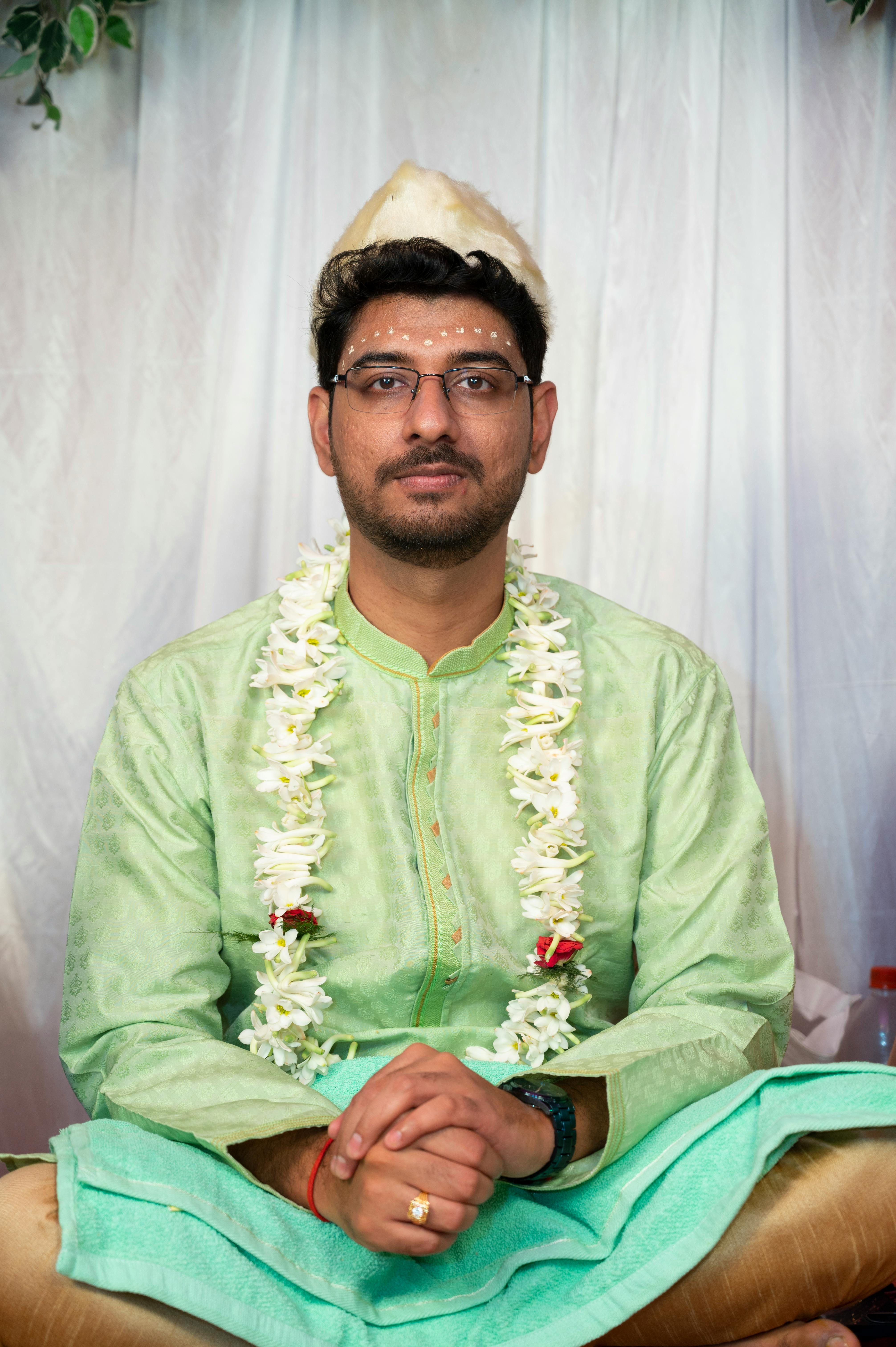 Man in Traditional Clothing and Garland Sitting · Free Stock Photo