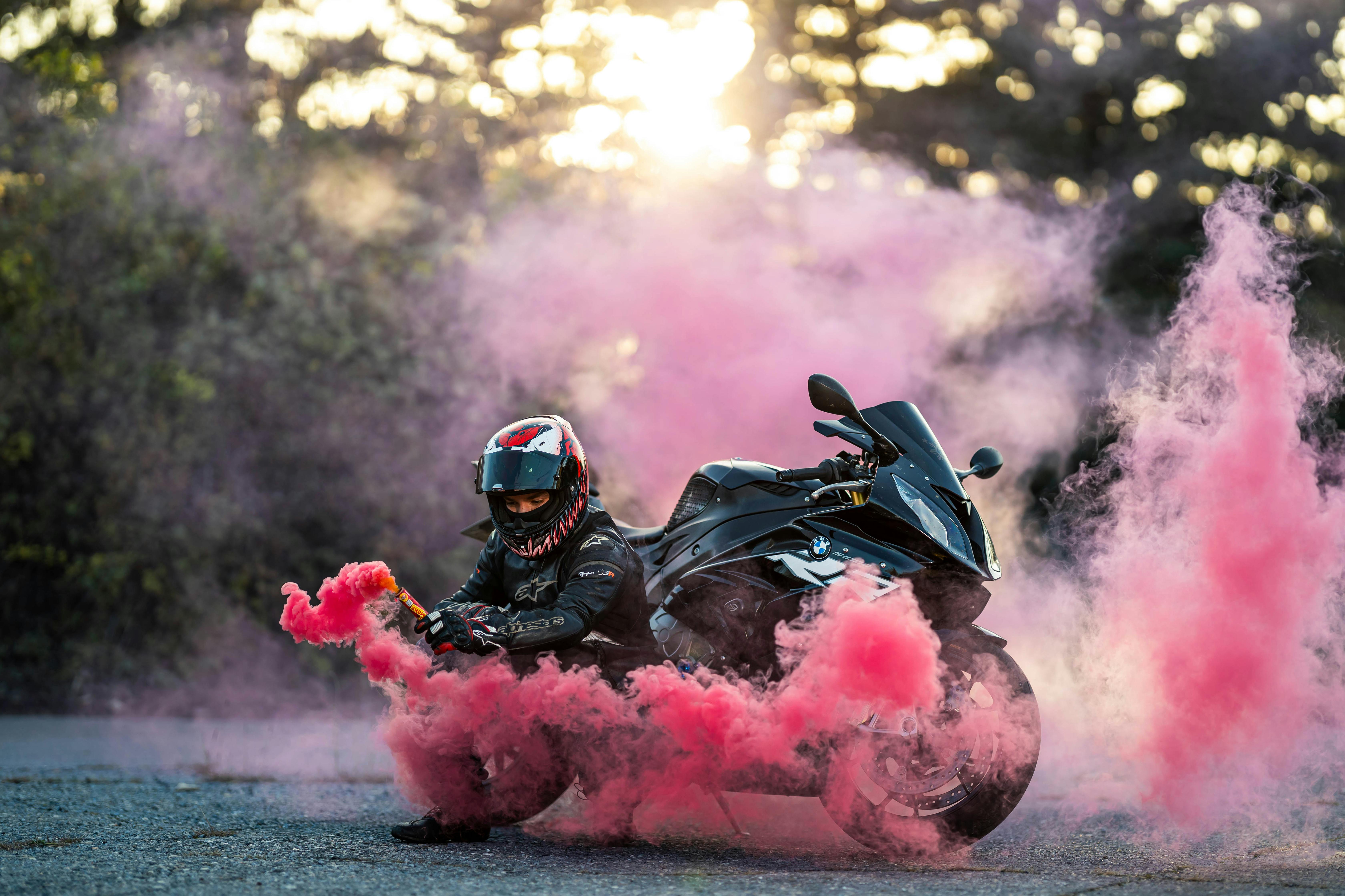 Person Crouching next to a Motorcycle and Holding a Smoke Flare · Free ...