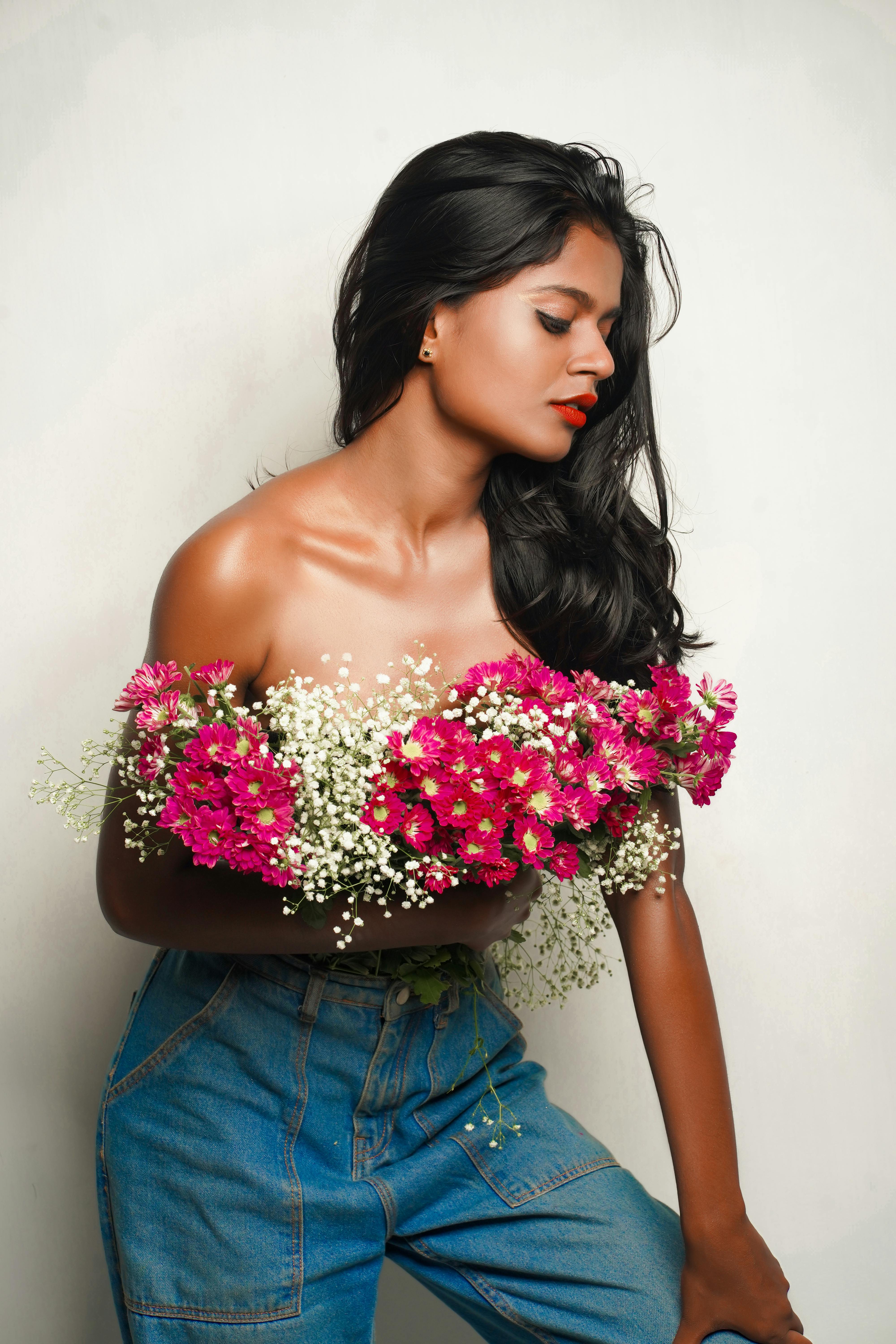 Model with Flowers Posing in Jeans · Free Stock Photo