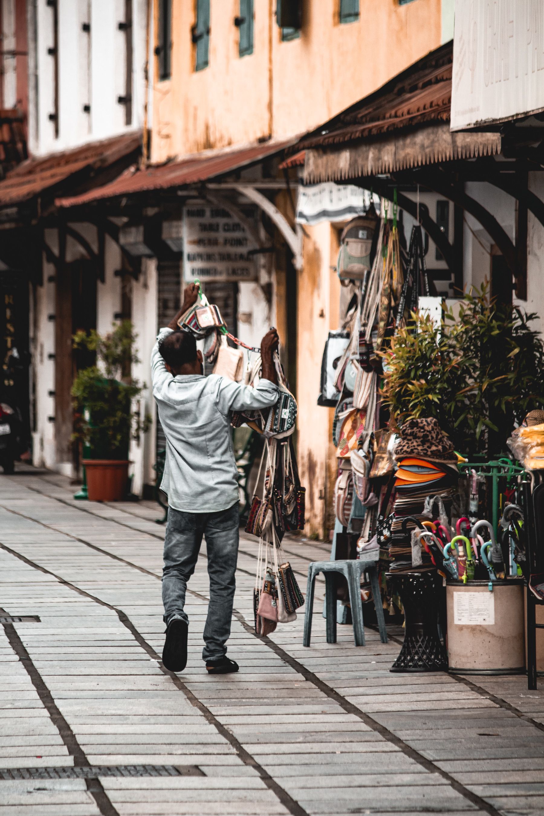 Man Carrying Items in front of a Store in a Town · Free Stock Photo