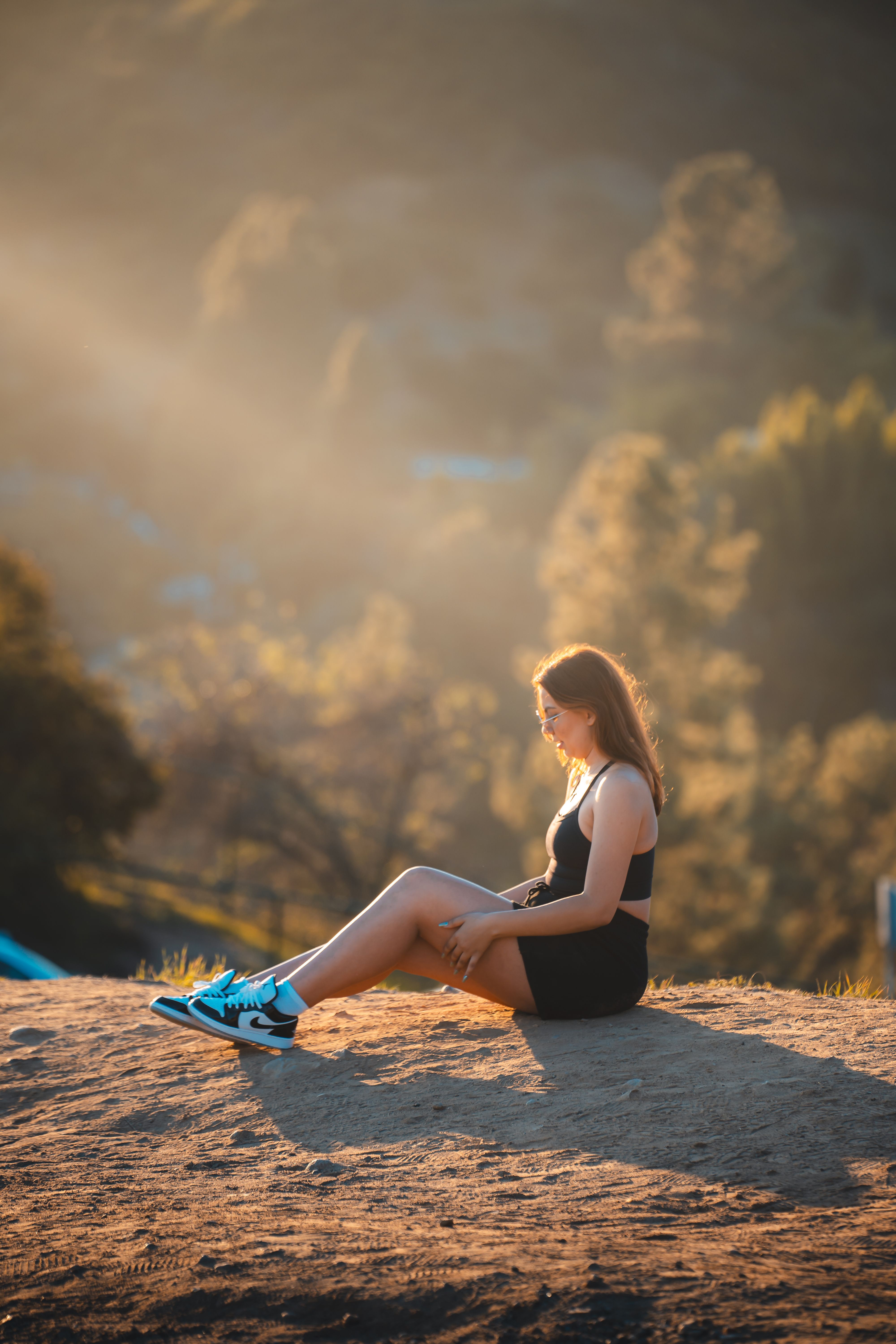 A Woman in White Crop Top and White Shorts Sitting on Brown Wooden ...