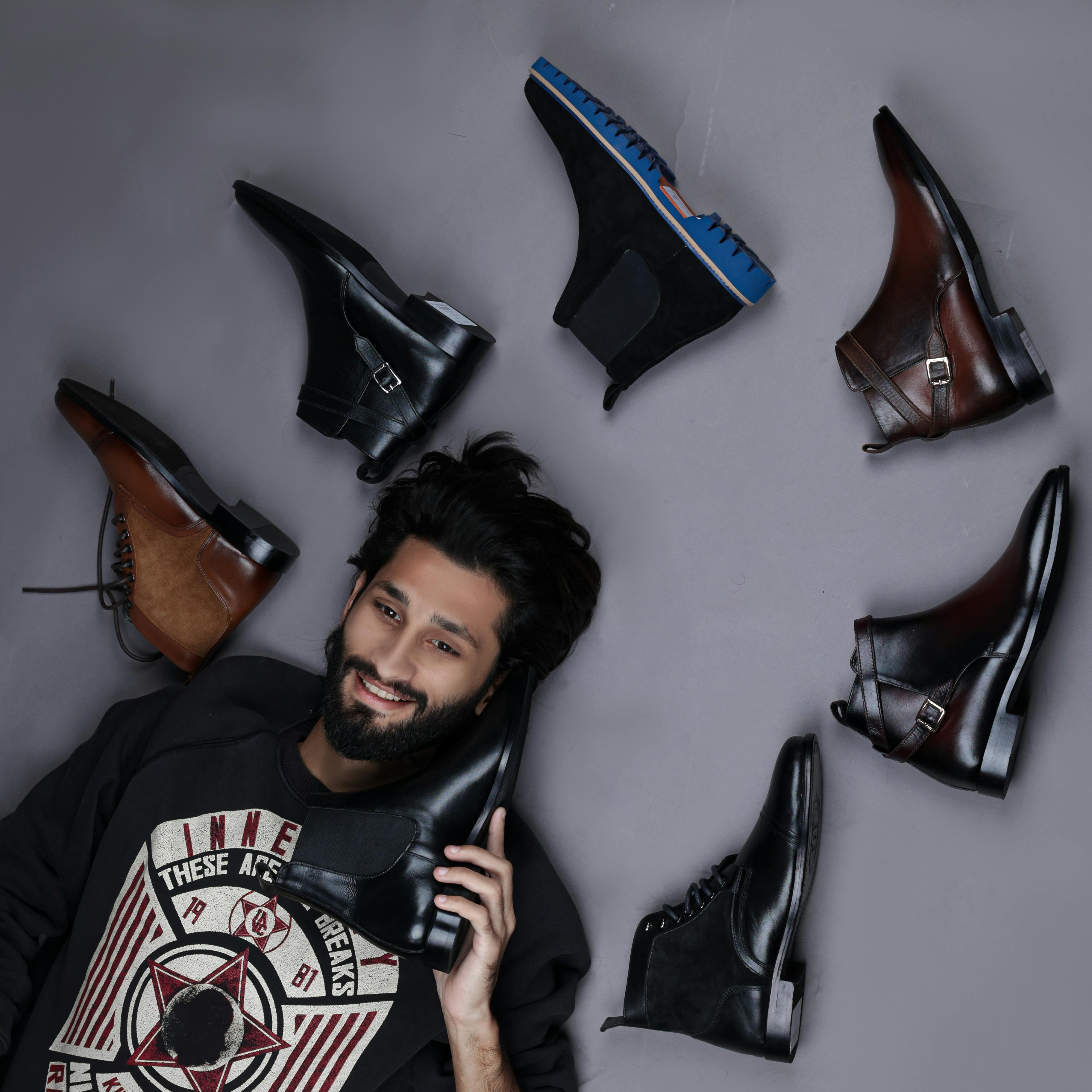Studio Shoot of a Man with Shoes against Gray Background · Free Stock Photo