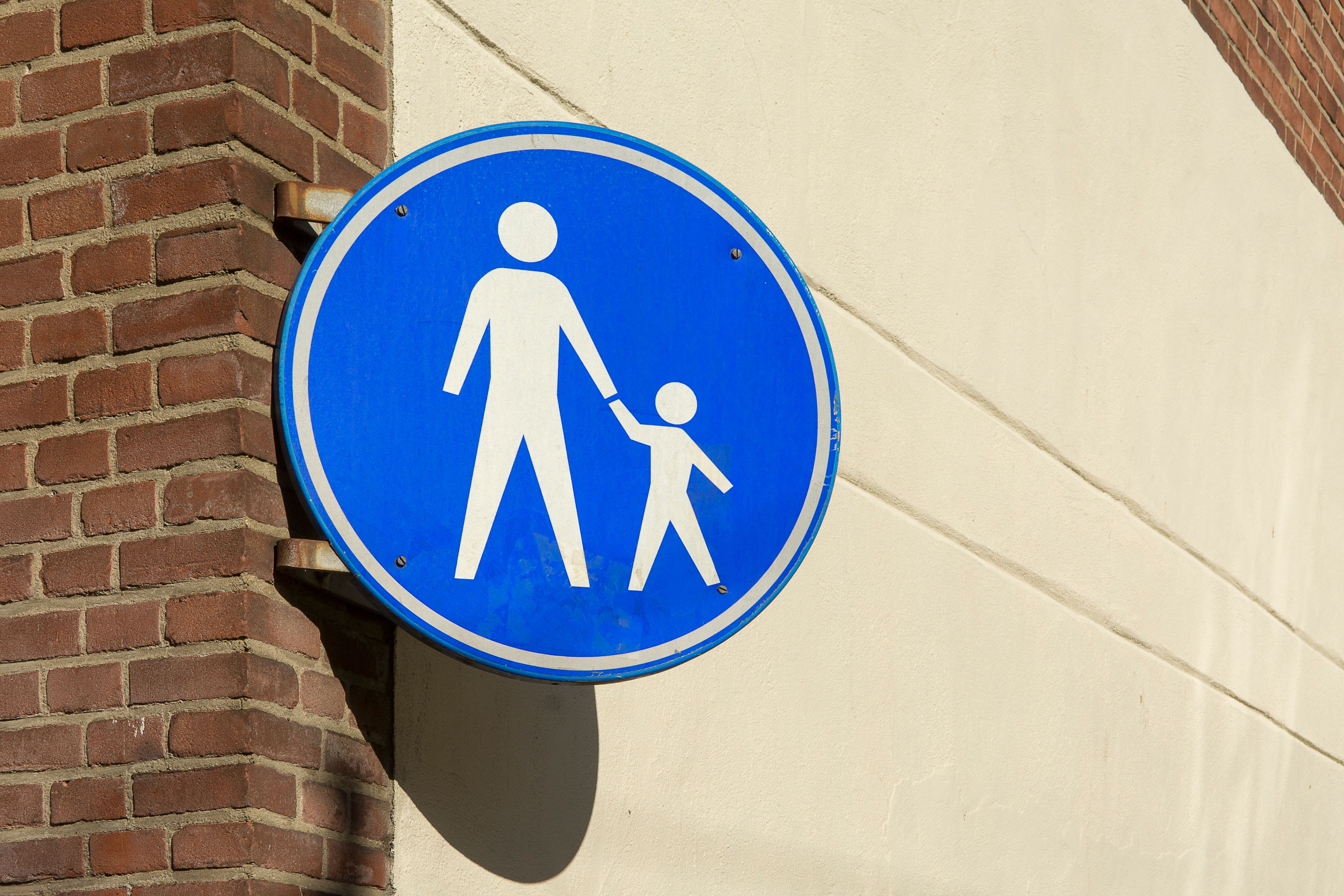 A blue and white sign with a man and a child walking · Free Stock Photo