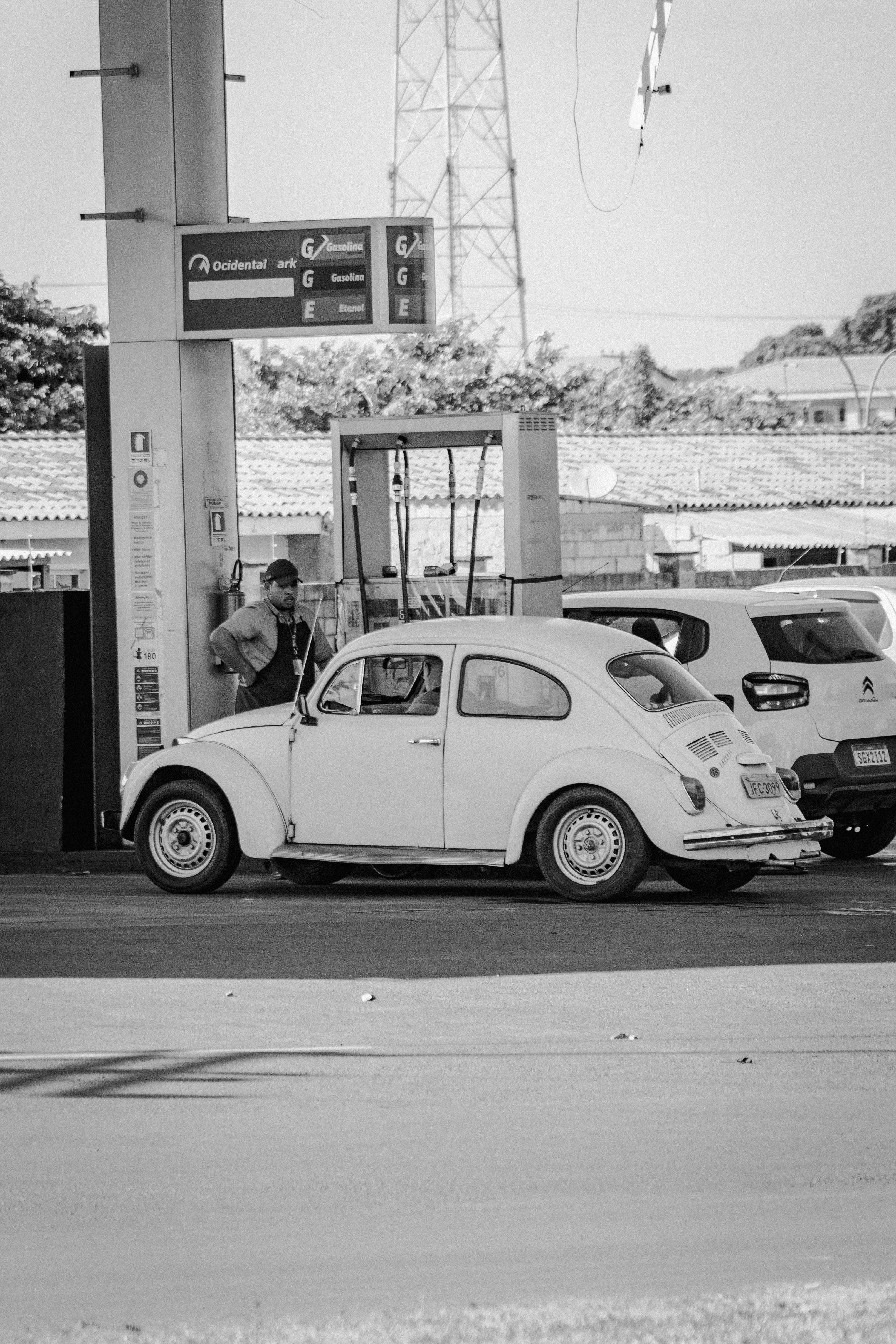 Man Filling Up a White Volkswagen Beetle at a Gas Station · Free Stock ...