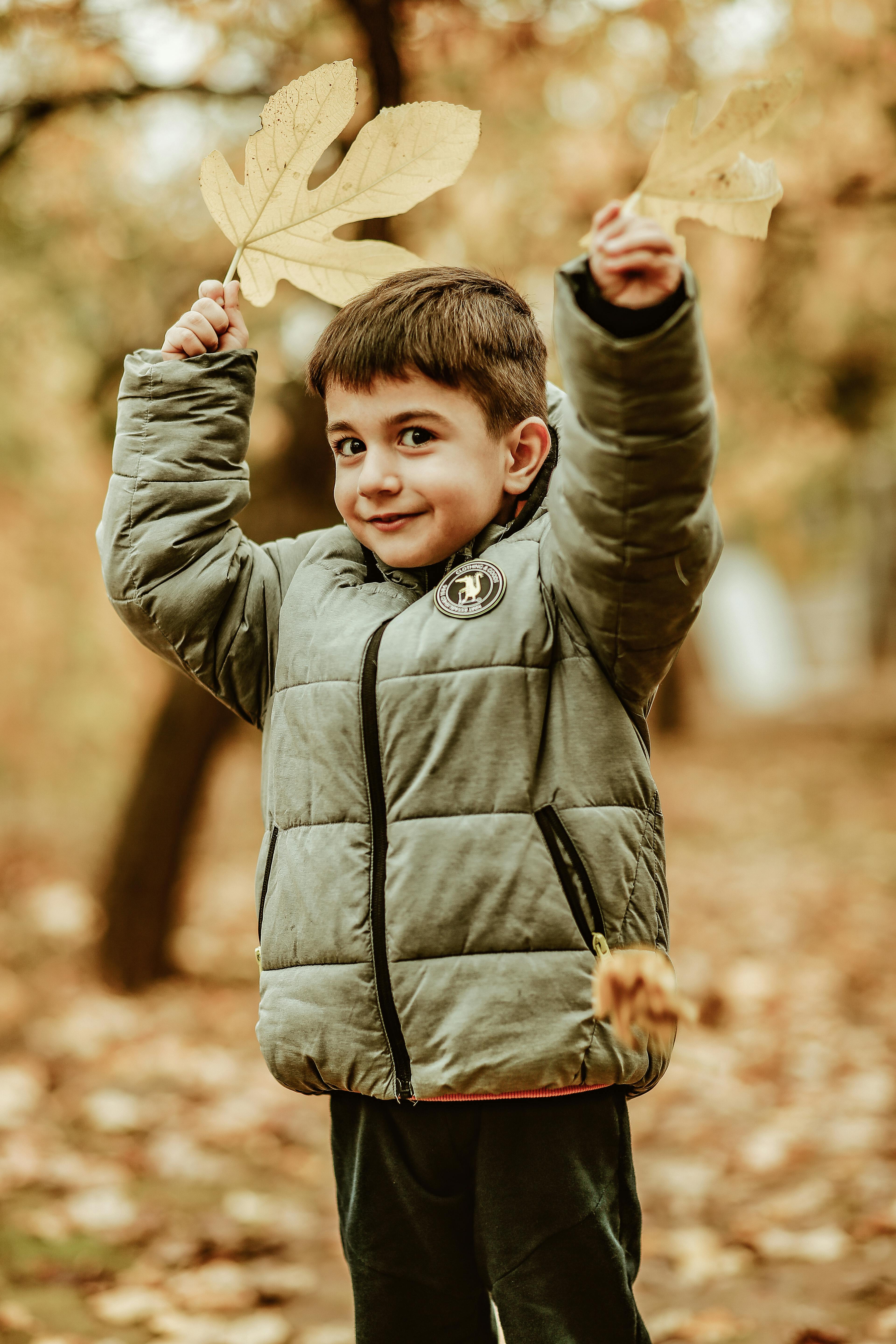 Boy Playing With Fall Leaves Outdoors · Free Stock Photo