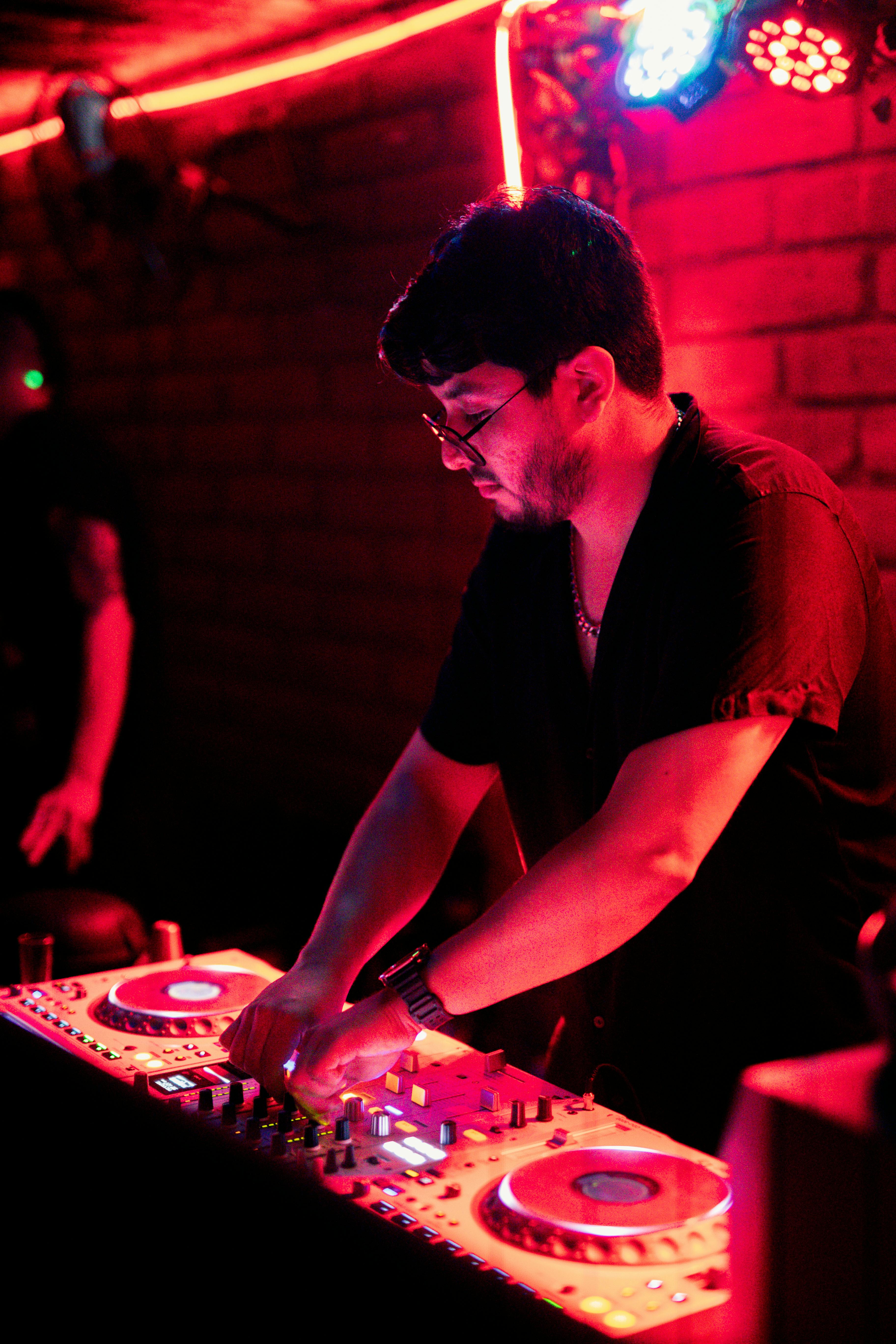 DJ with Eyeglasses on Stage in Nightclub · Free Stock Photo