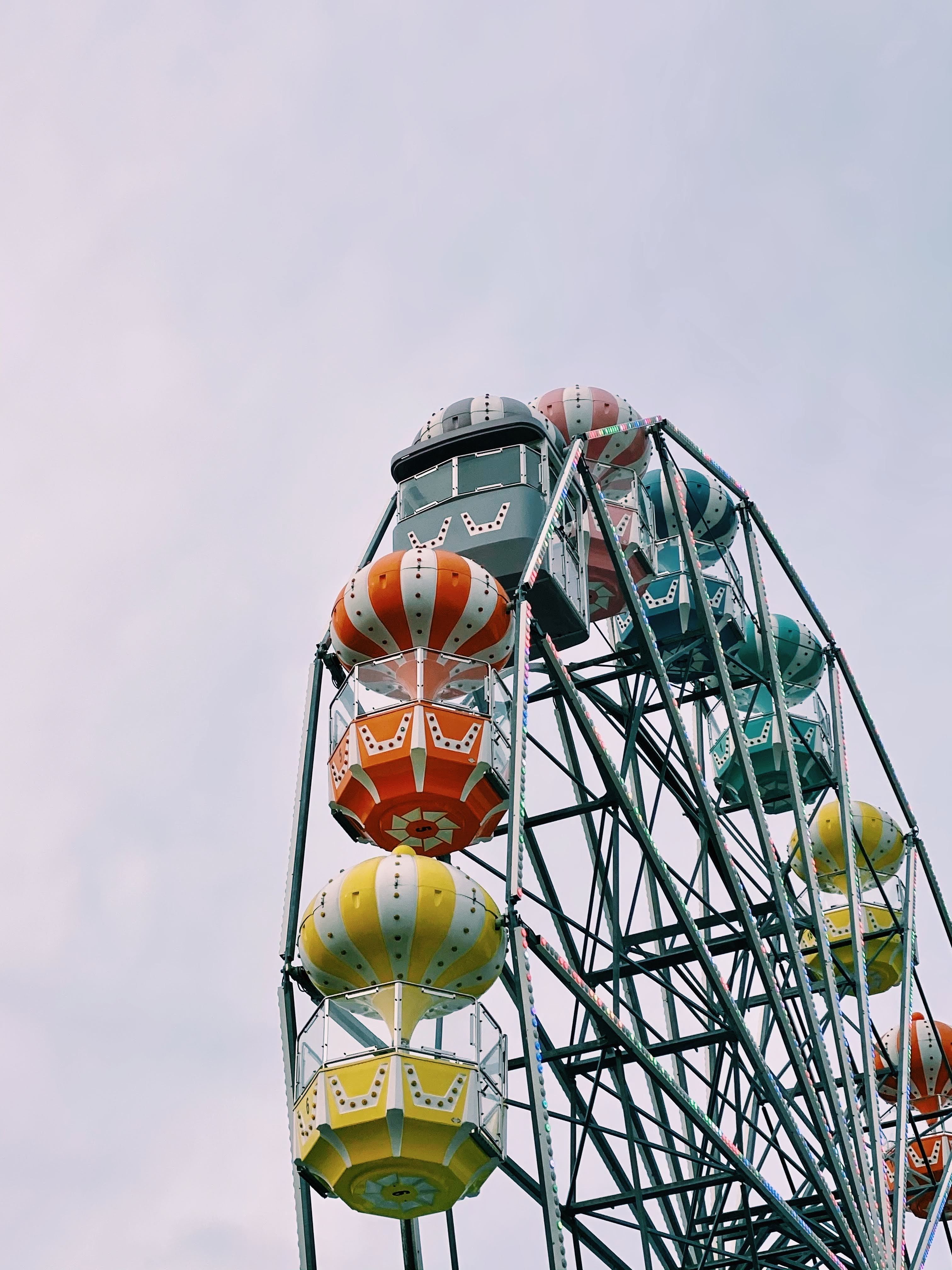 Woman Facing Ferris Wheel While Making Heart Hand Sign · Free Stock Photo