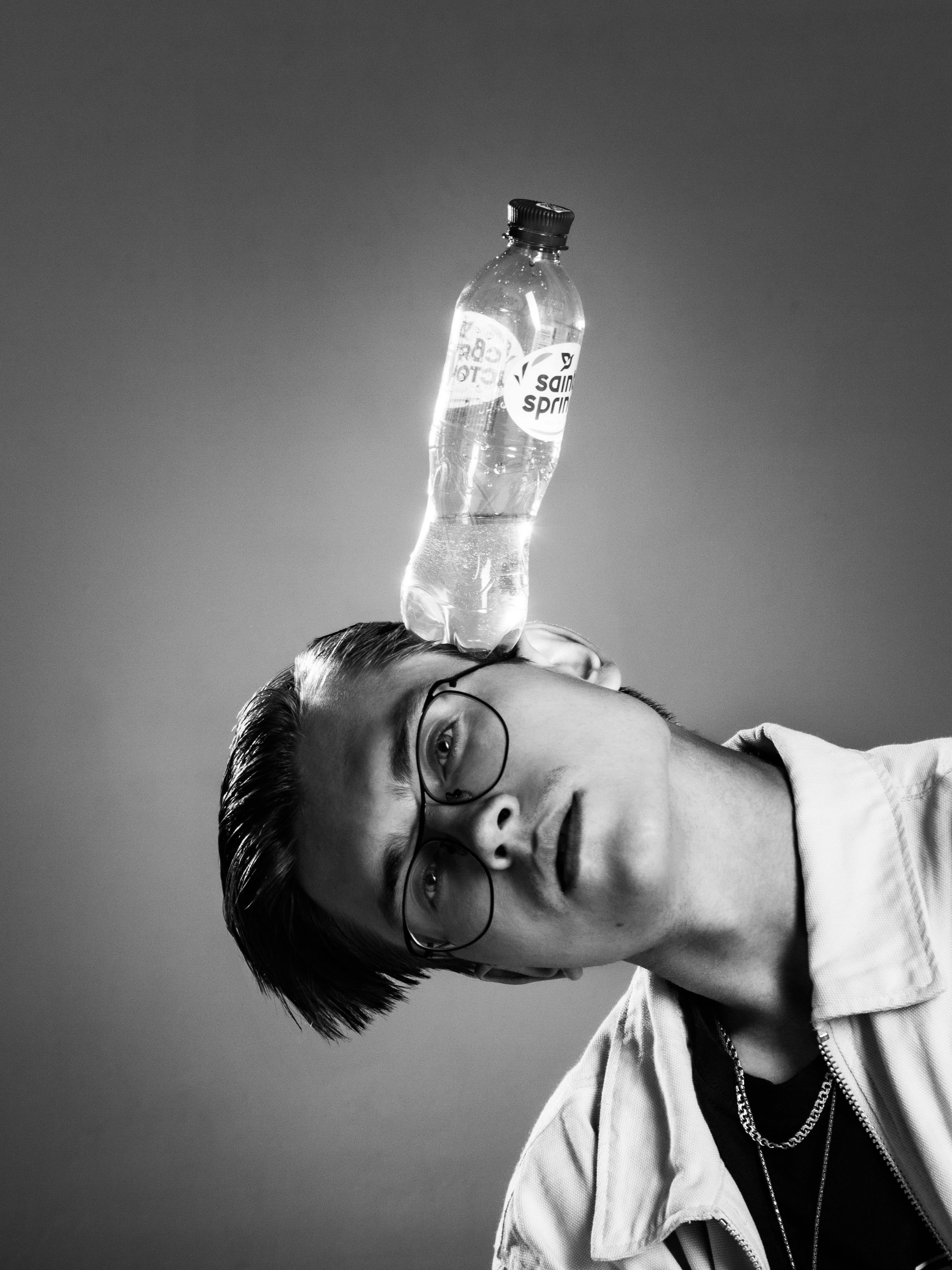 Young Man Posing with Plastic Bottle on Head · Free Stock Photo