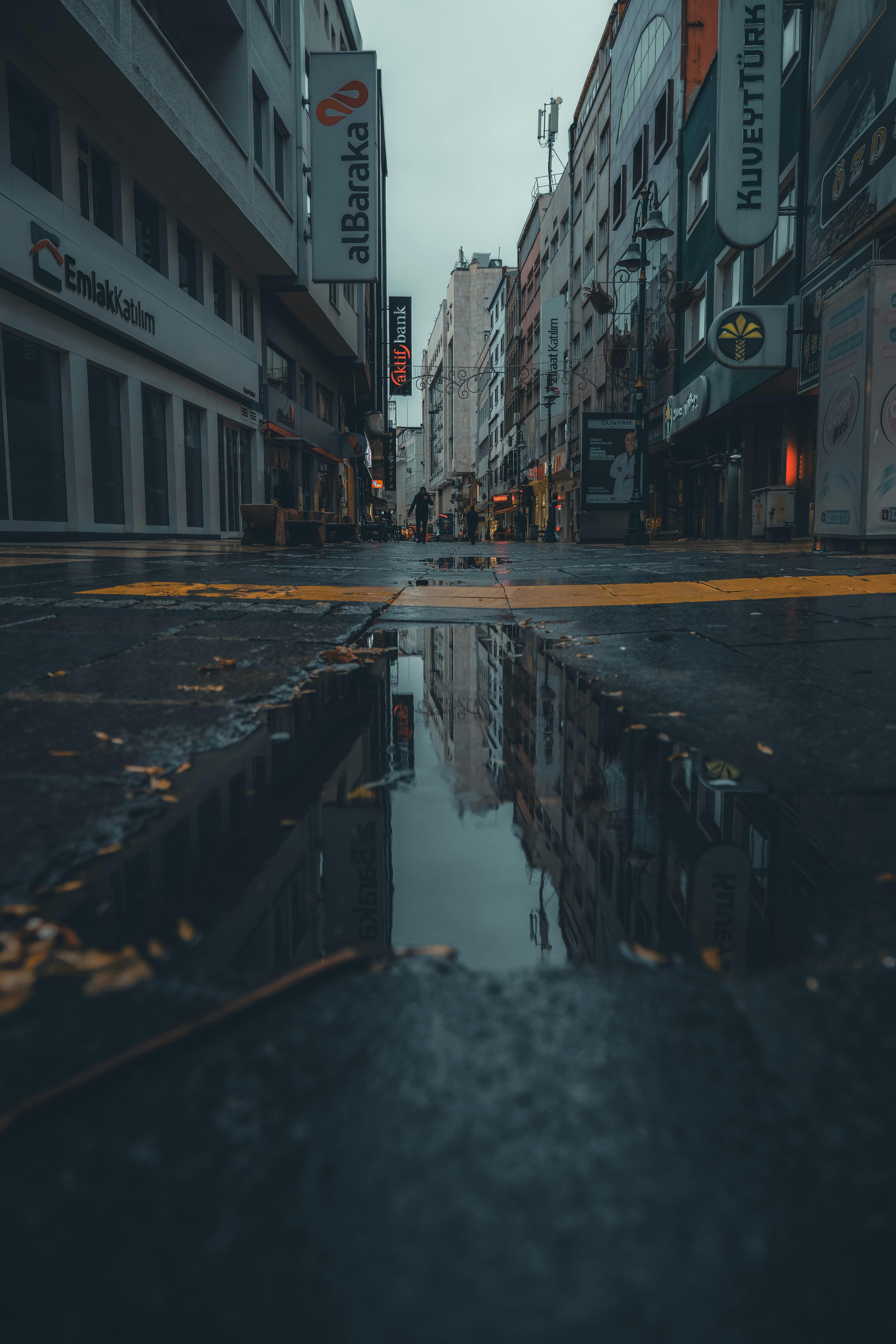 City Street with a Puddle in the Middle at Dusk · Free Stock Photo