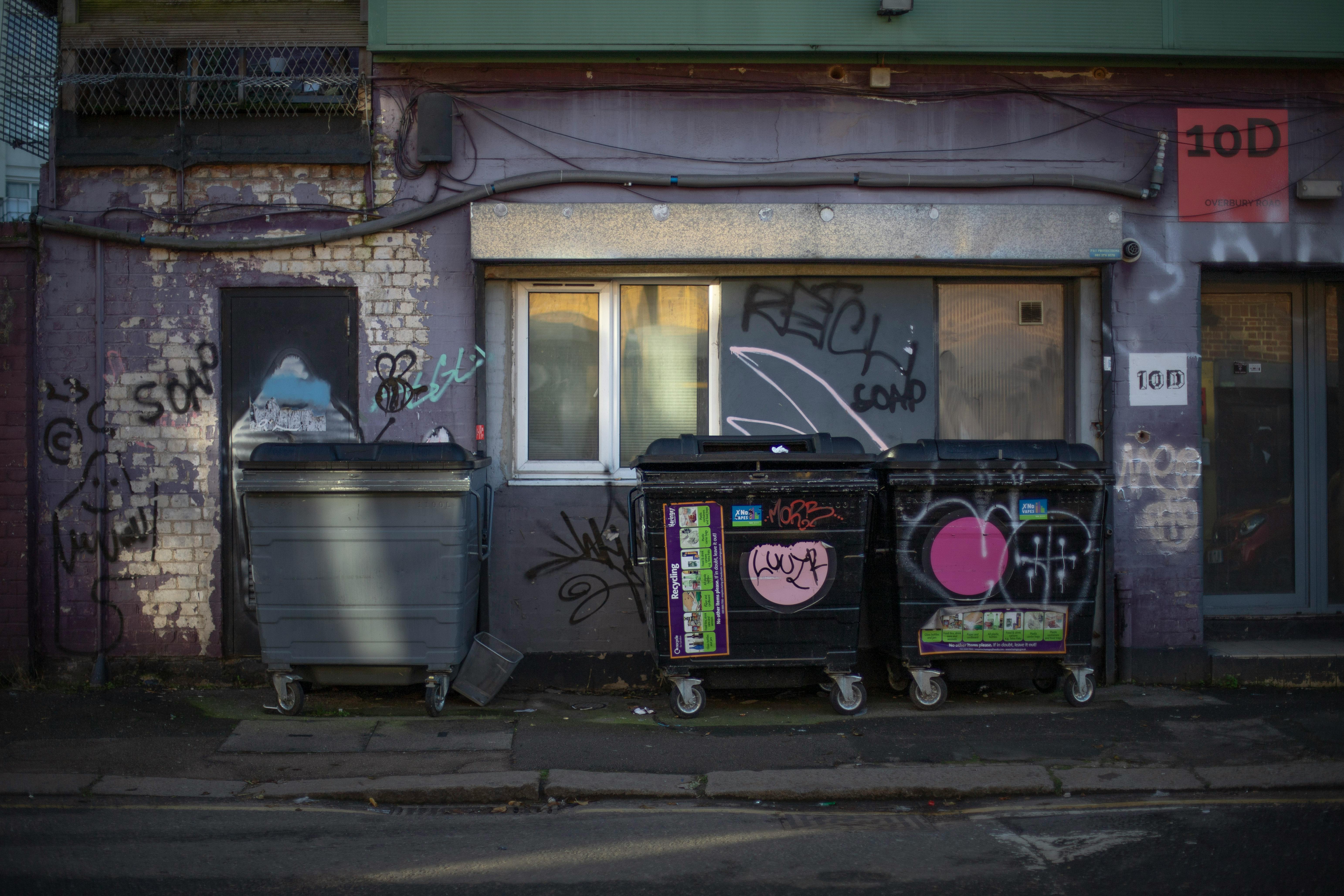 Garbage Bins near House Wall · Free Stock Photo