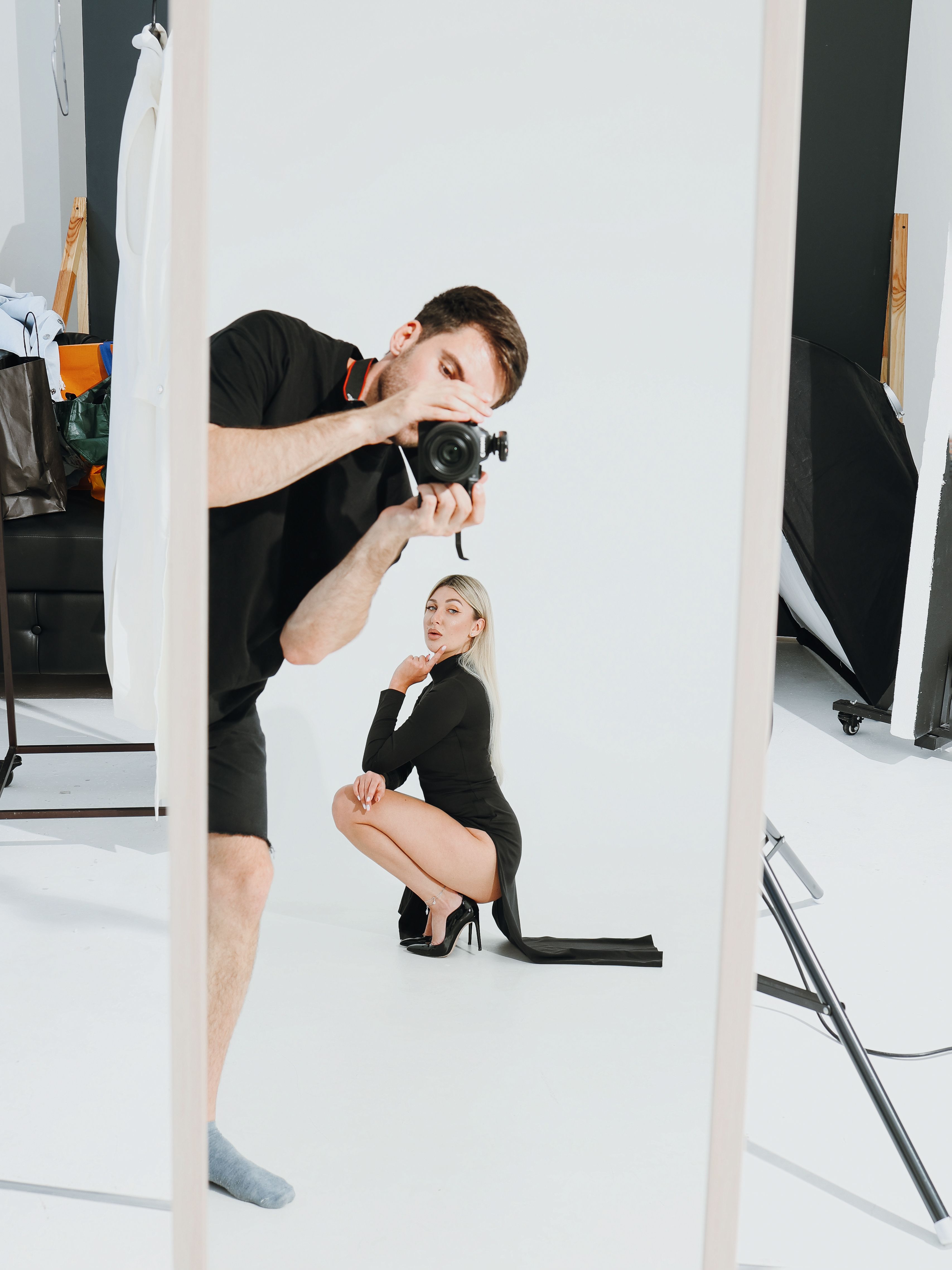 Man Photographing Reflection of Posing Model · Free Stock Photo