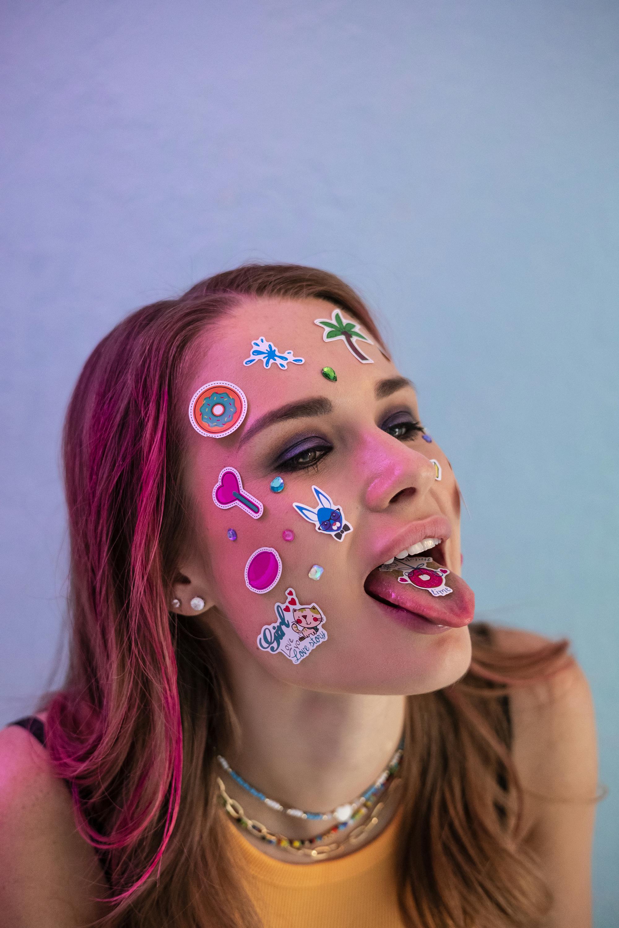 Serious female with stickers on face blowing bubble with gum · Free ...