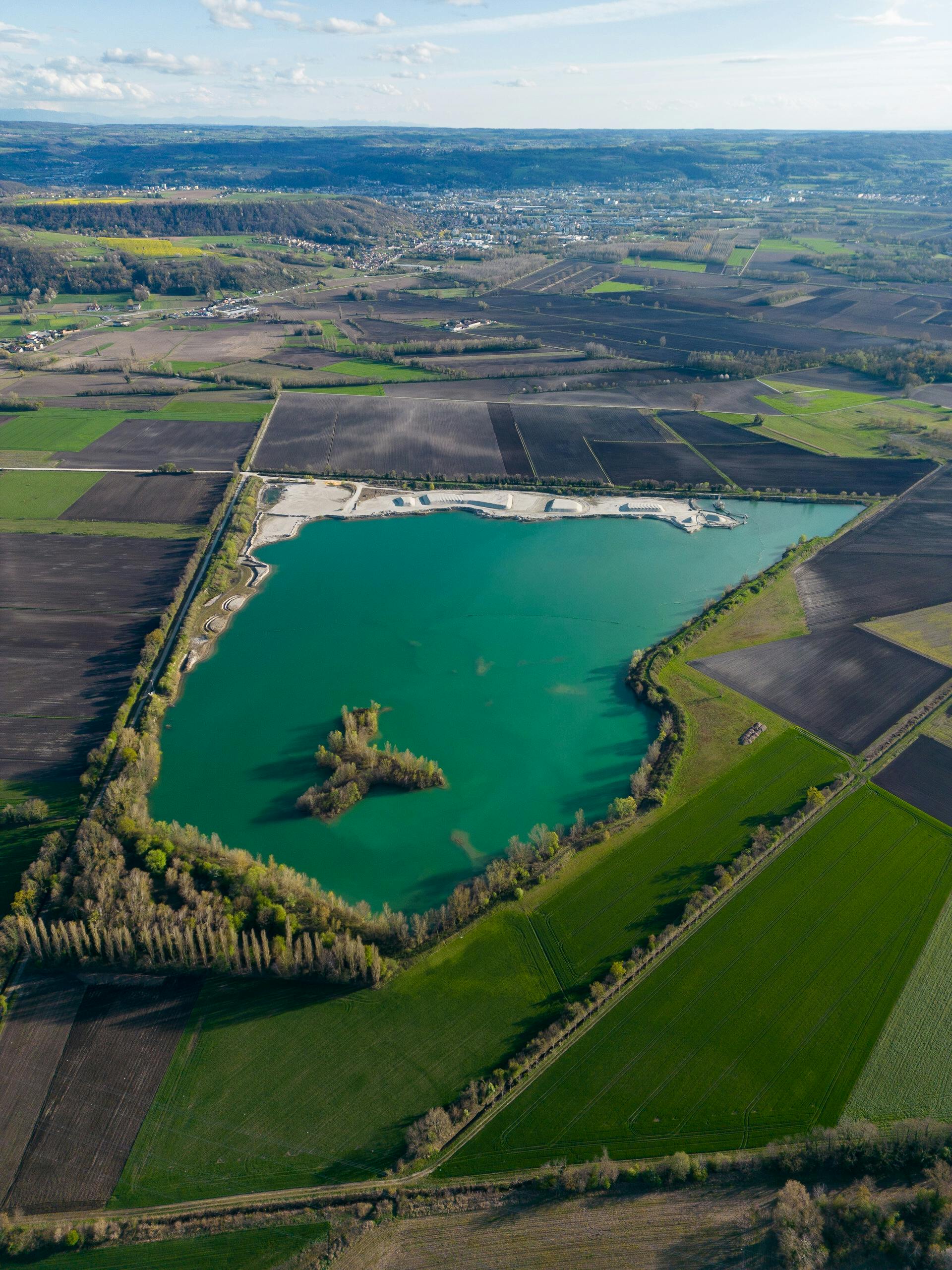 Aerial Footage of Fields and a Water Reservoir · Free Stock Photo