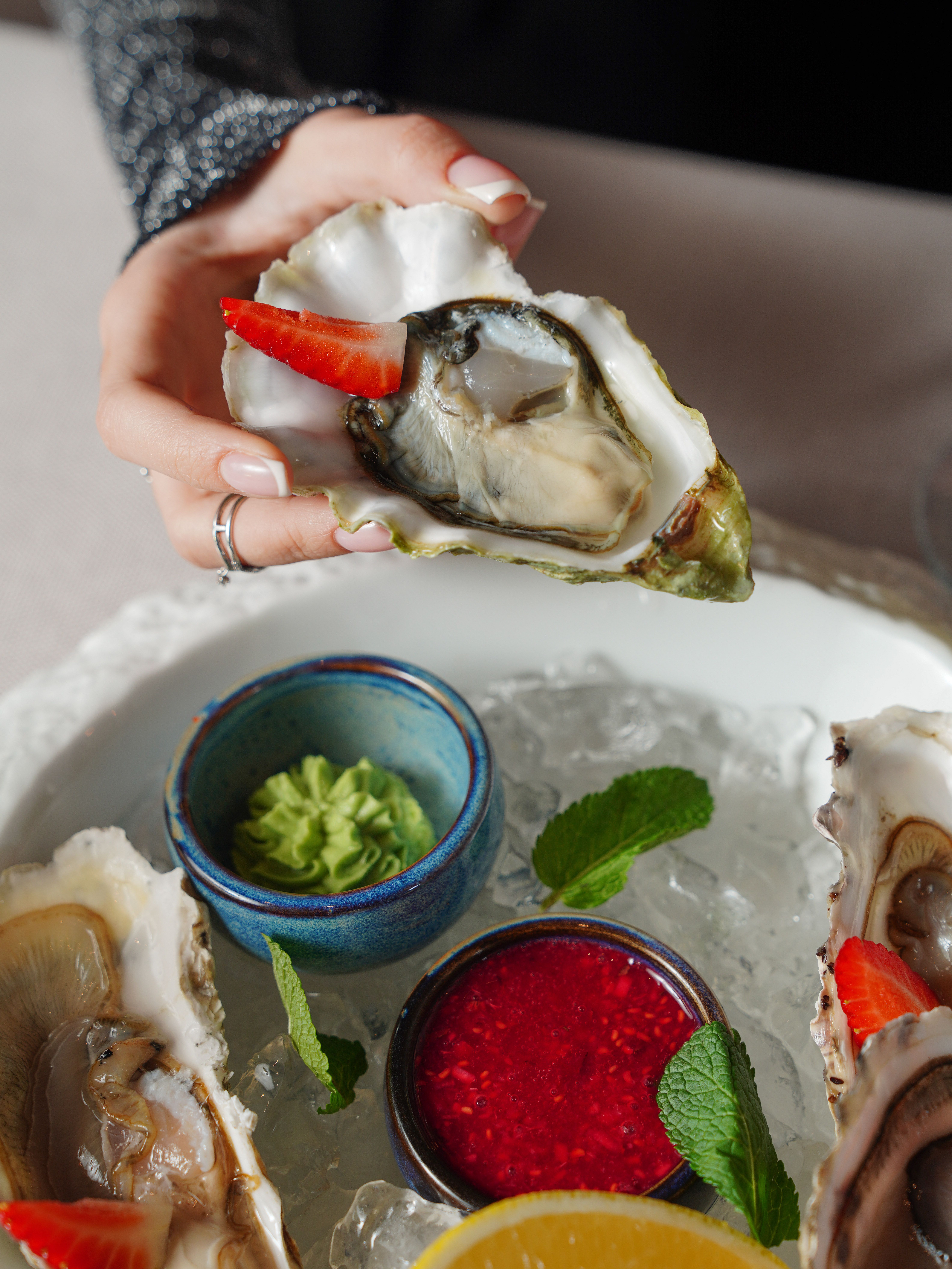 Woman Taking an Open Oyster from an Iced Bowl · Free Stock Photo
