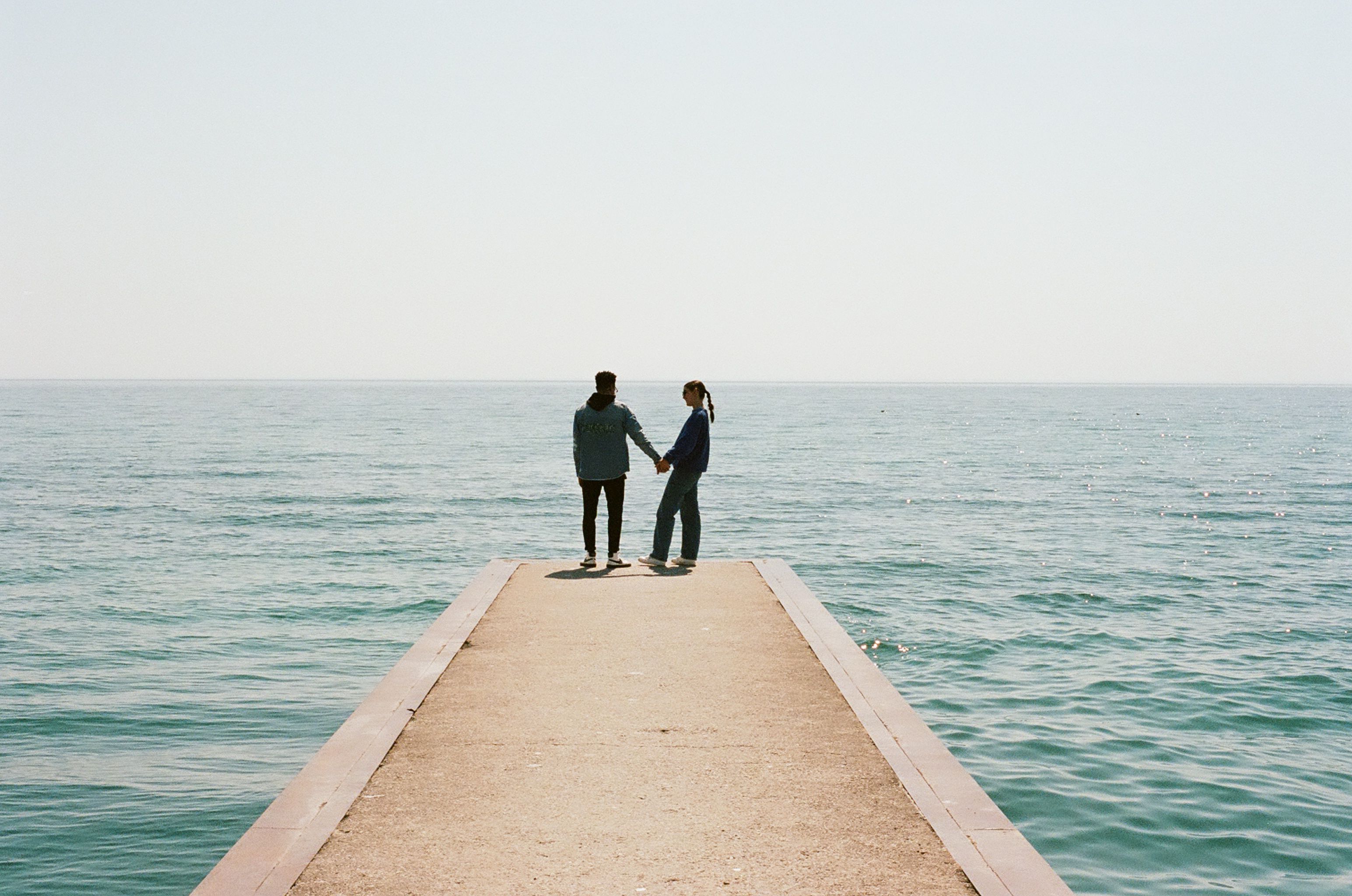 Romantic Couple on Pier in Sea · Free Stock Photo