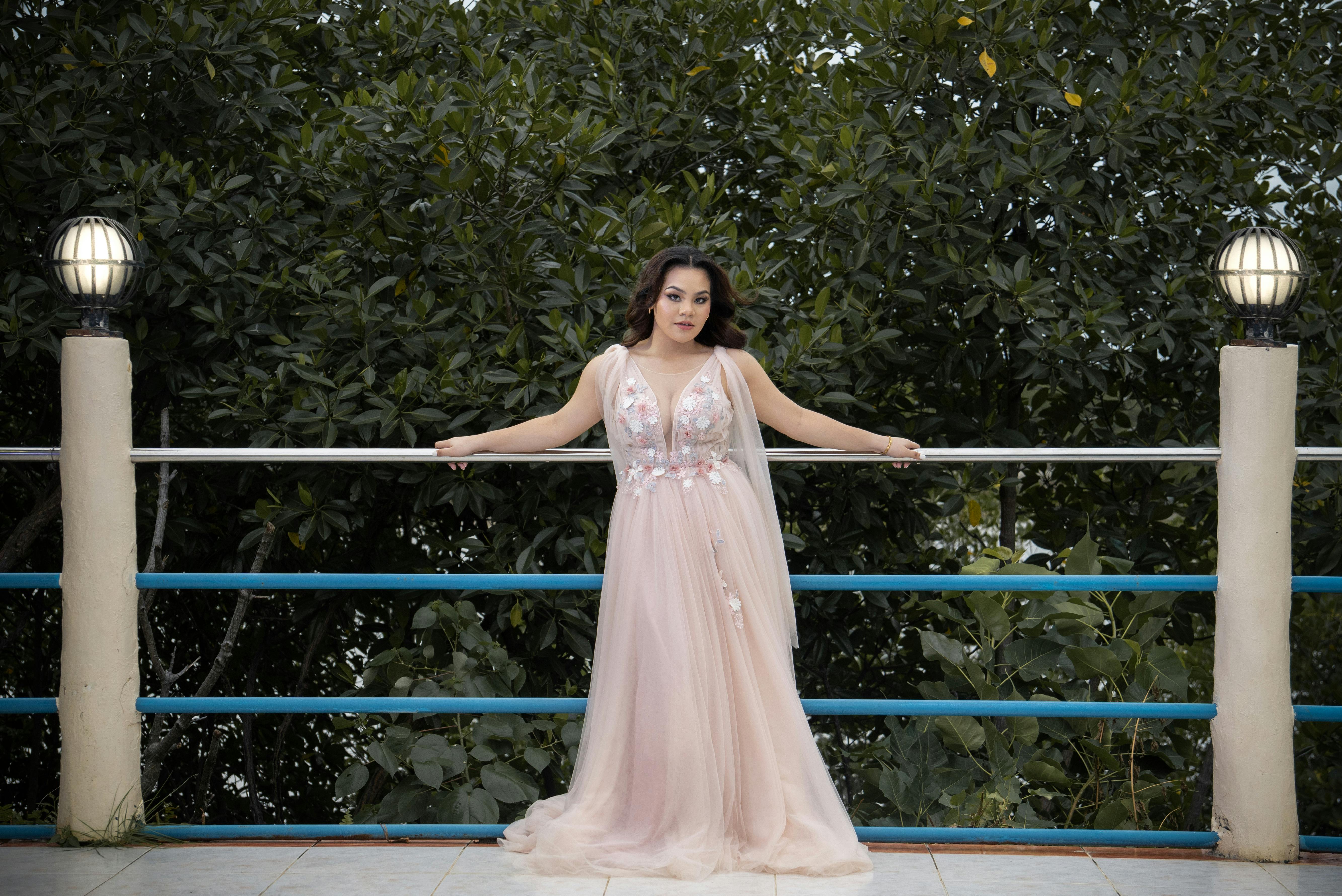 Woman in a Long Pink Gown Standing on the Bridge · Free Stock Photo