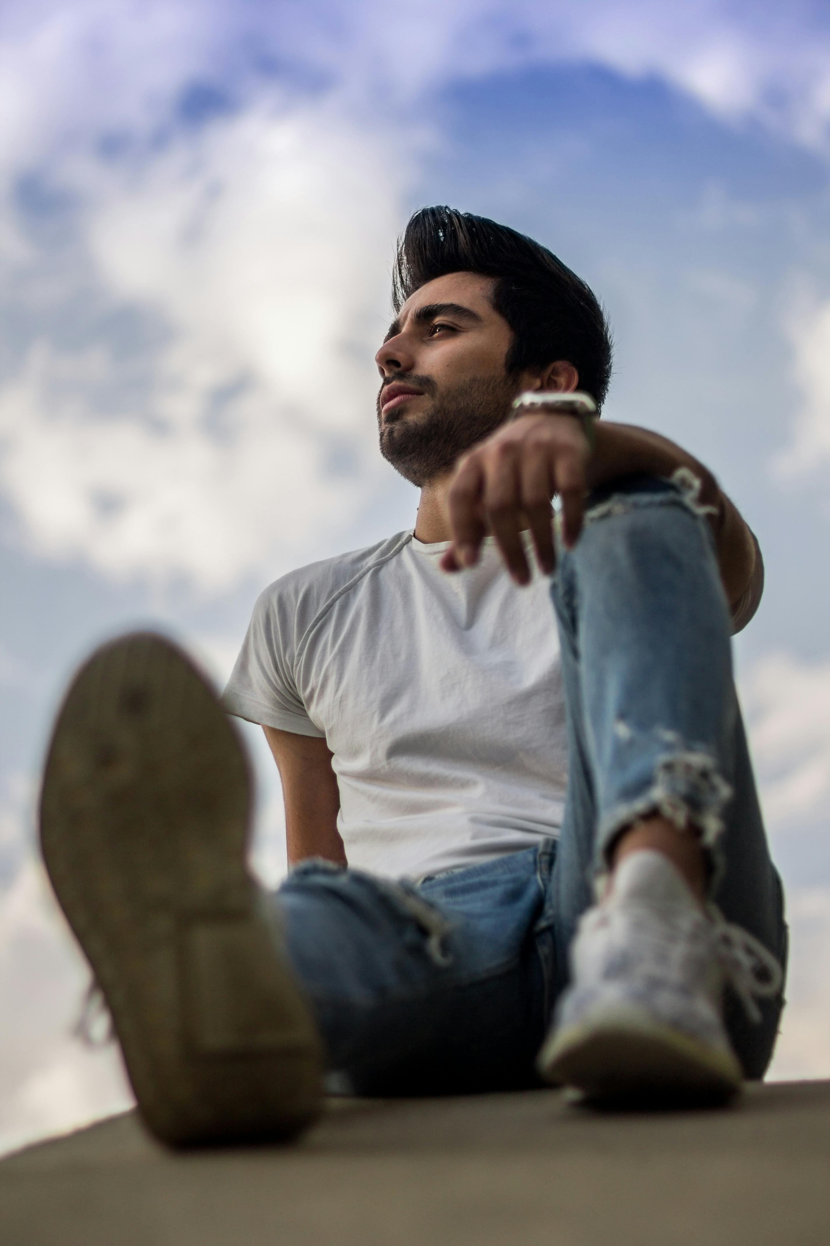 A Smiling Man Crouching in front of a Plant · Free Stock Photo