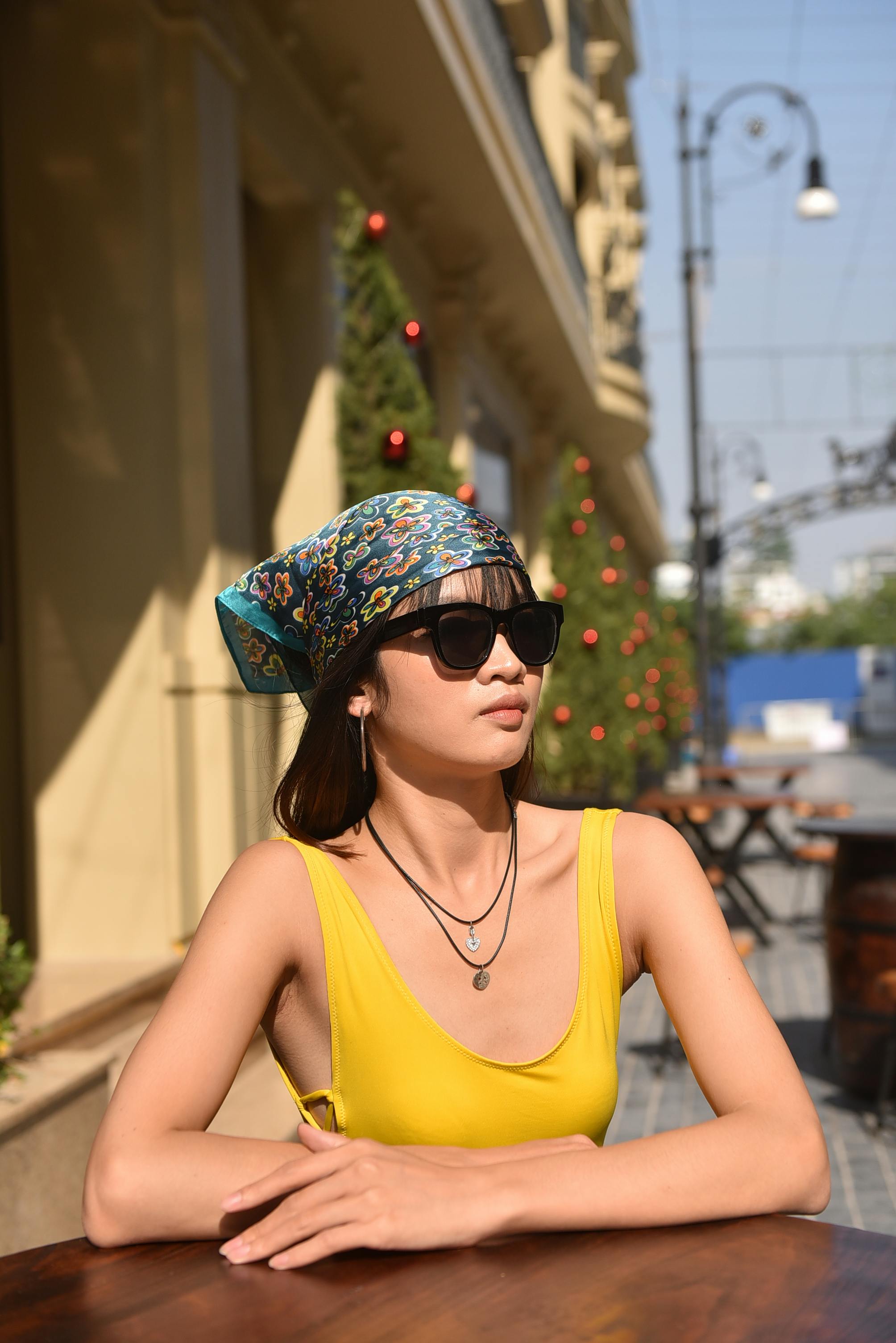 Woman in a Headscarf and Sunglasses Sitting by a Table · Free Stock Photo