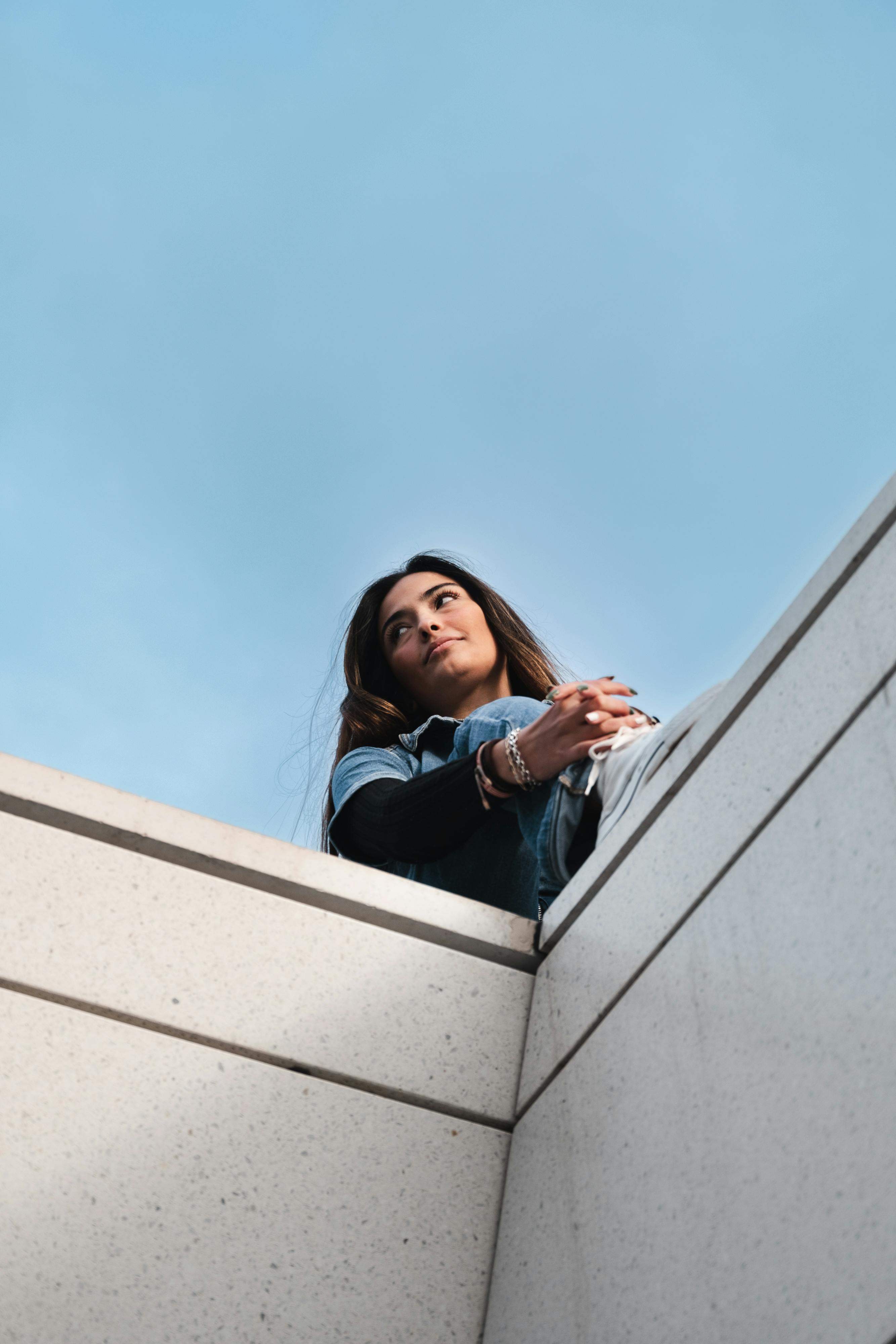 Smiling Woman Sitting on Wall · Free Stock Photo