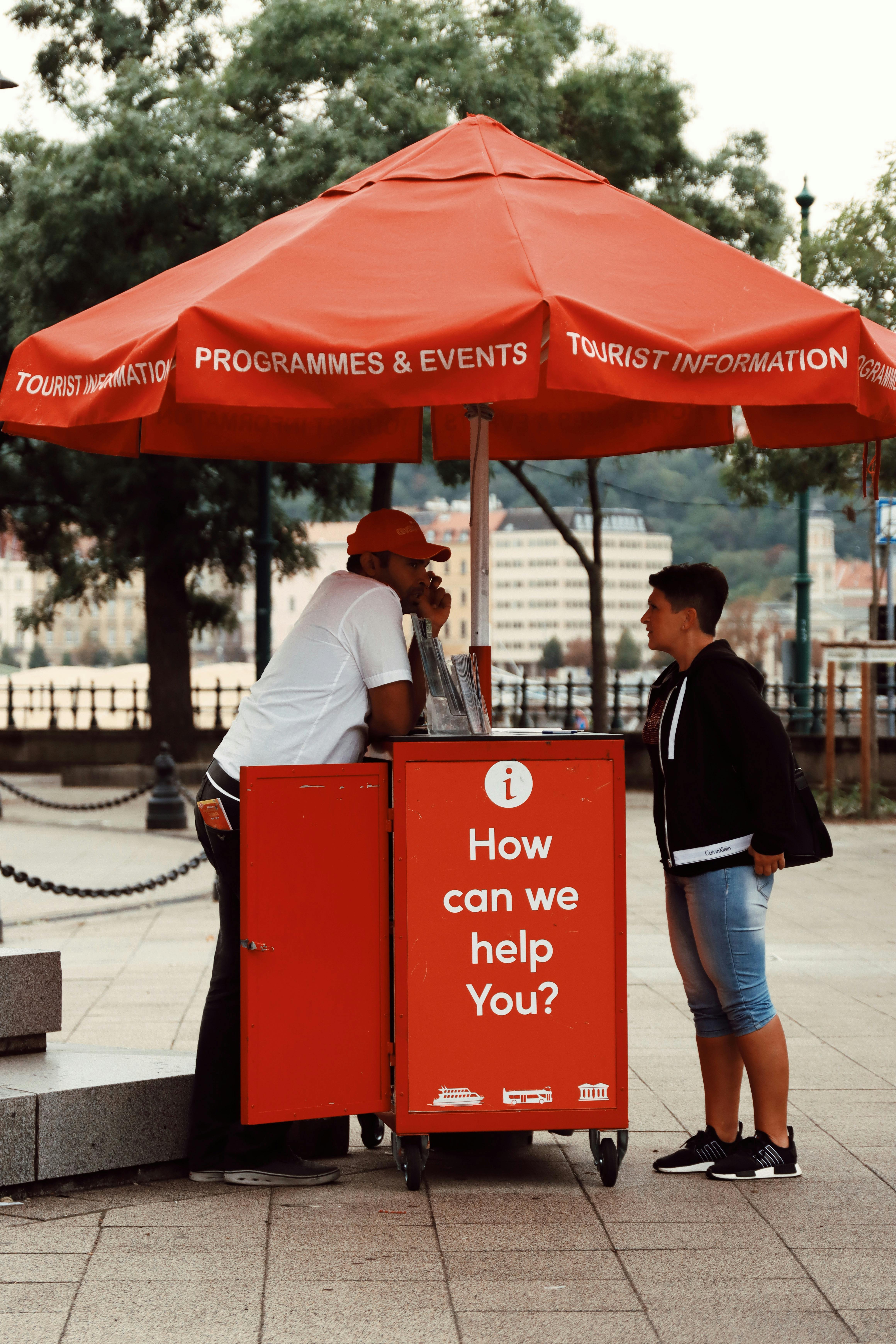 People by the Red Booth on a Square · Free Stock Photo