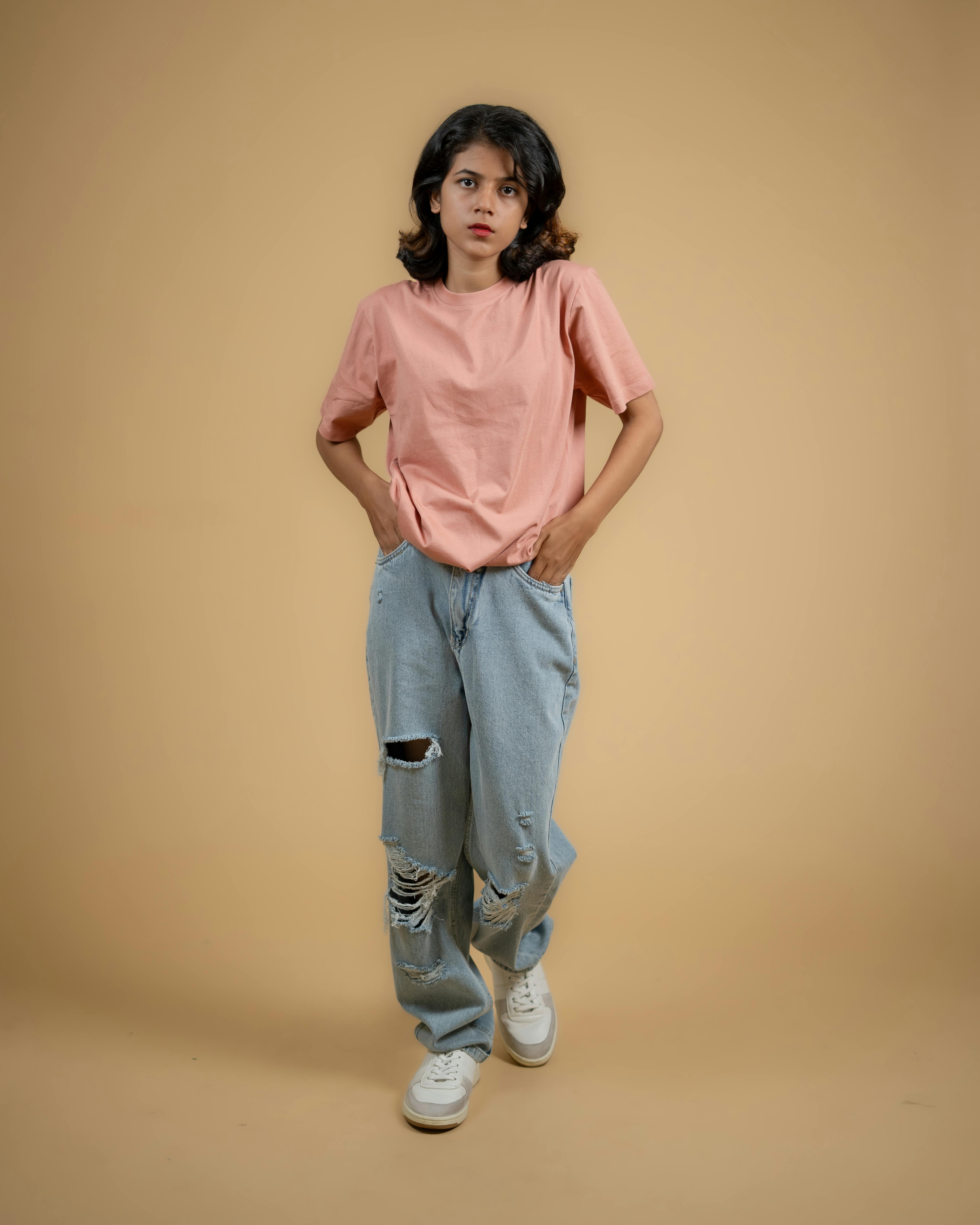 Young Model in a Pink T-shirt and Jeans Posing in the Studio · Free ...