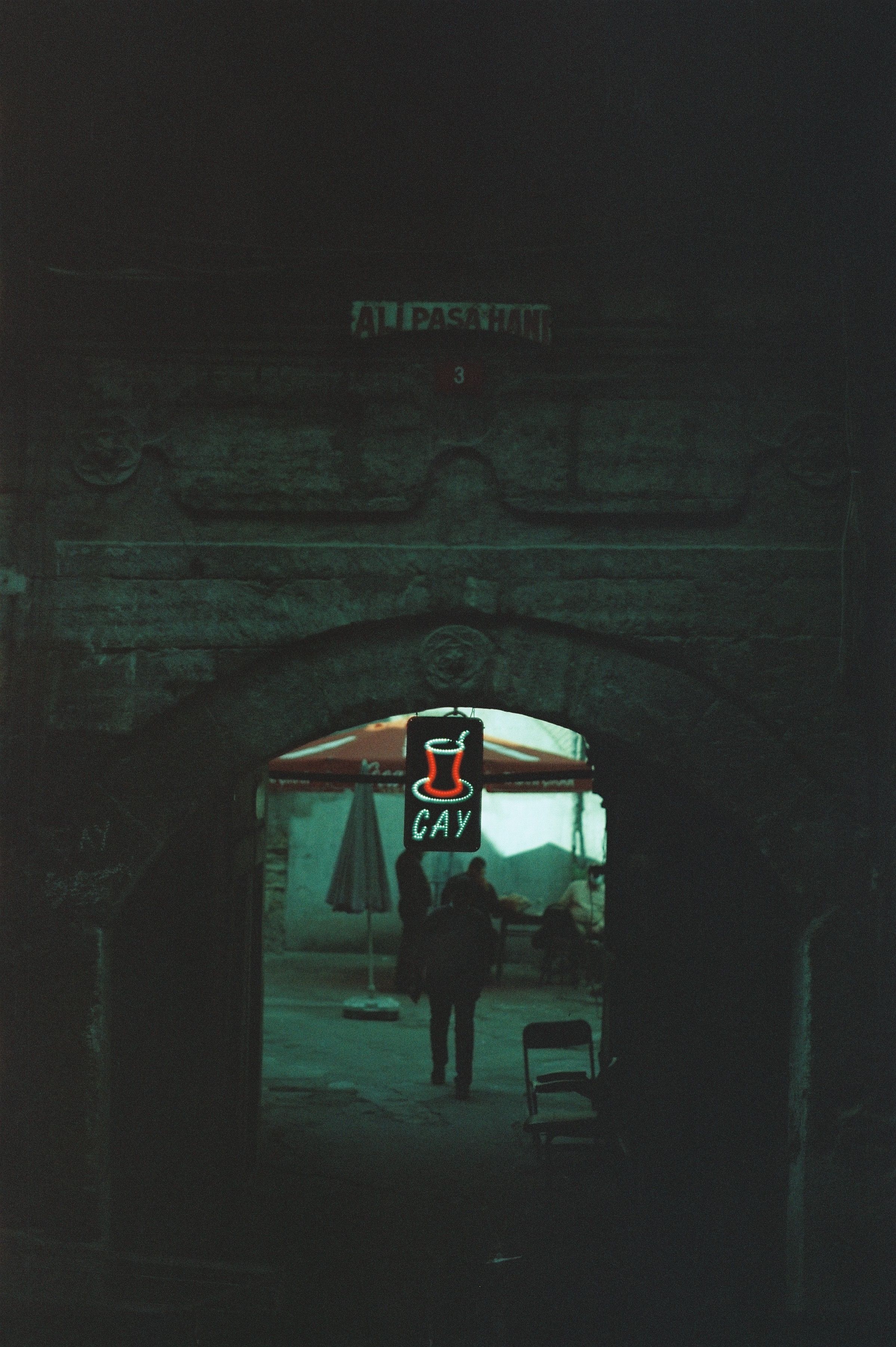 A Sign of a Cafe Hanging under an Arched Passage · Free Stock Photo