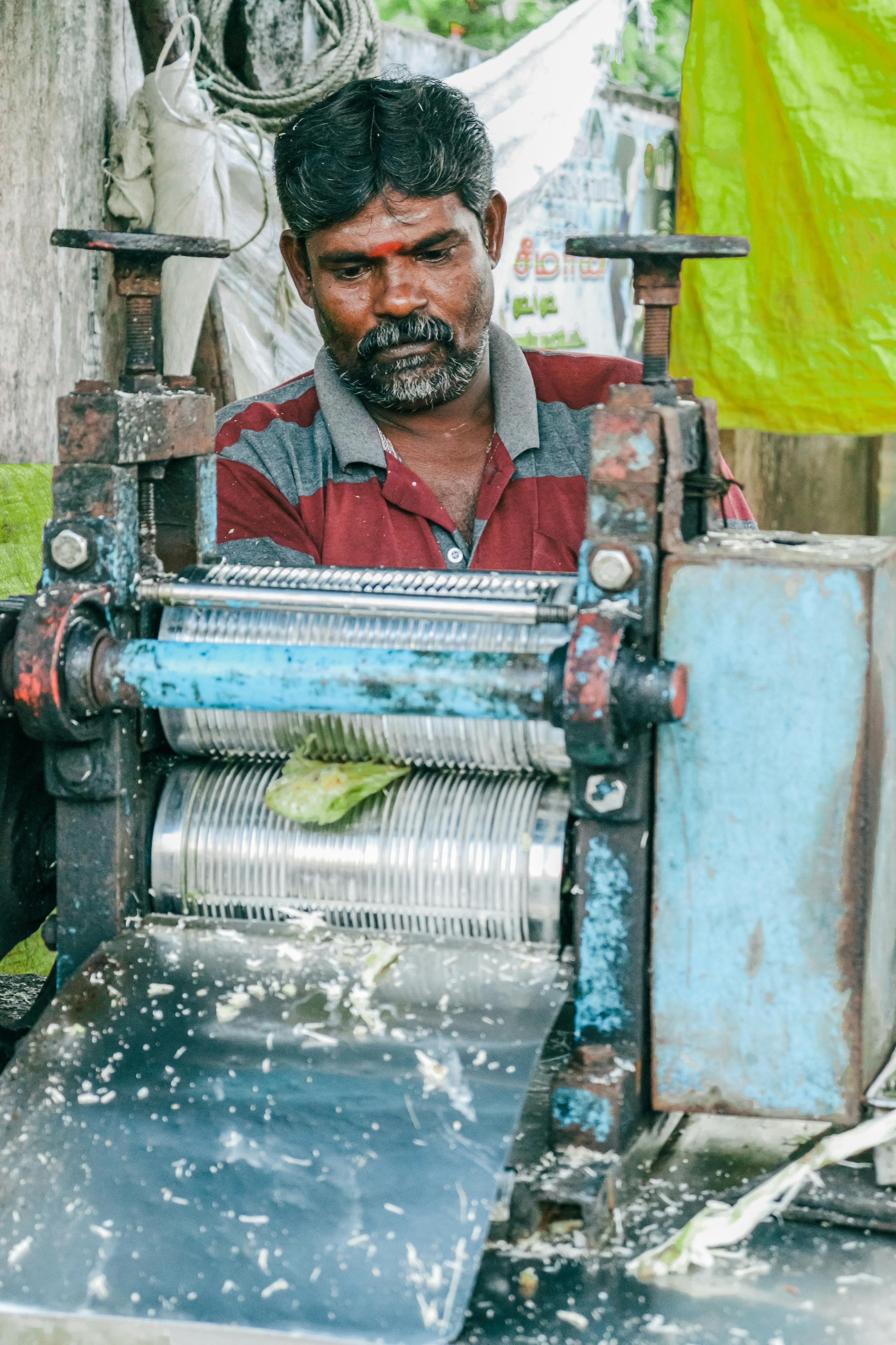 Man Producing Syrup Using a Grinder · Free Stock Photo