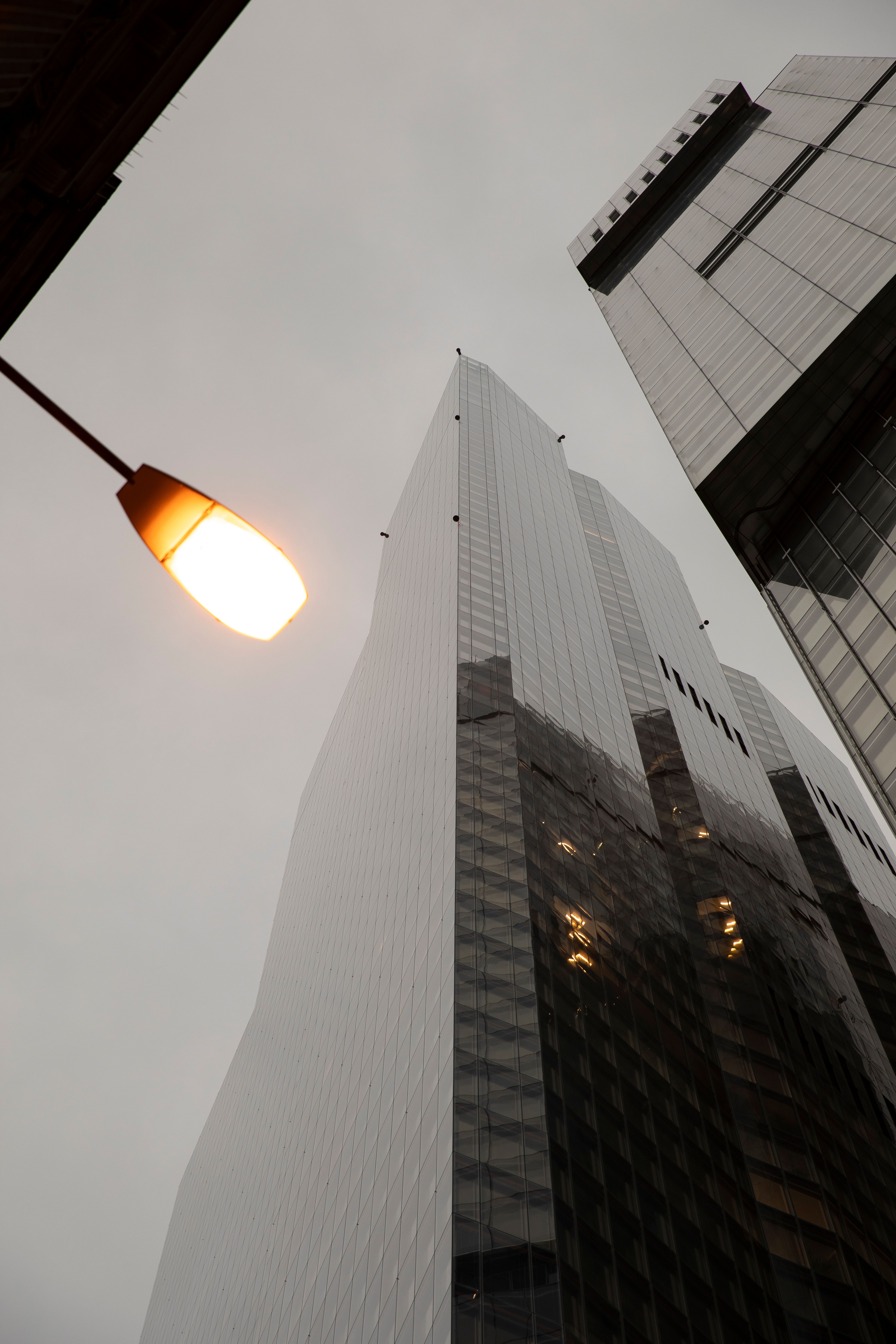 A street light is shown in front of tall buildings · Free Stock Photo