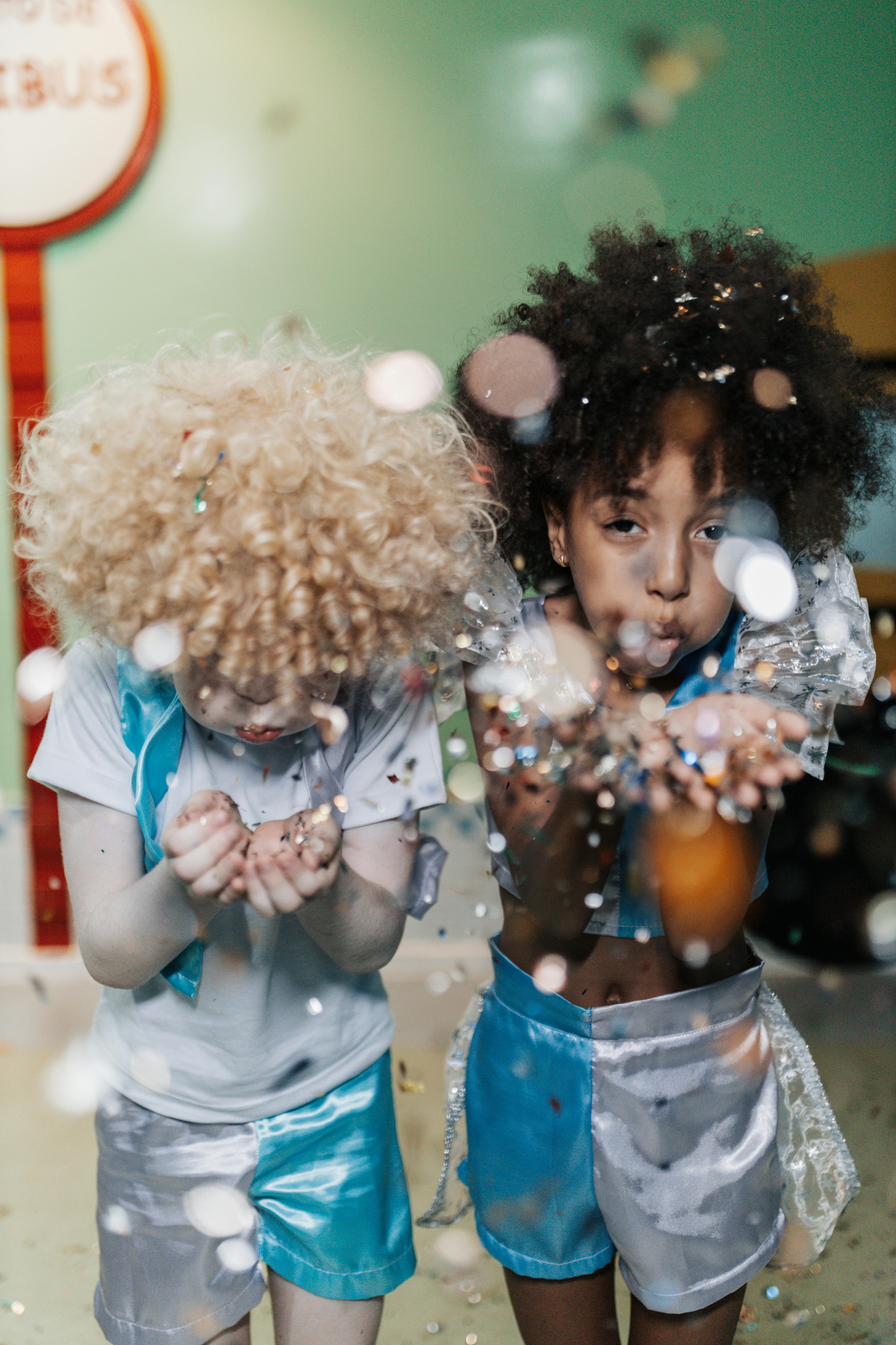 Children in Festive Costumes Playing with Confetti · Free Stock Photo