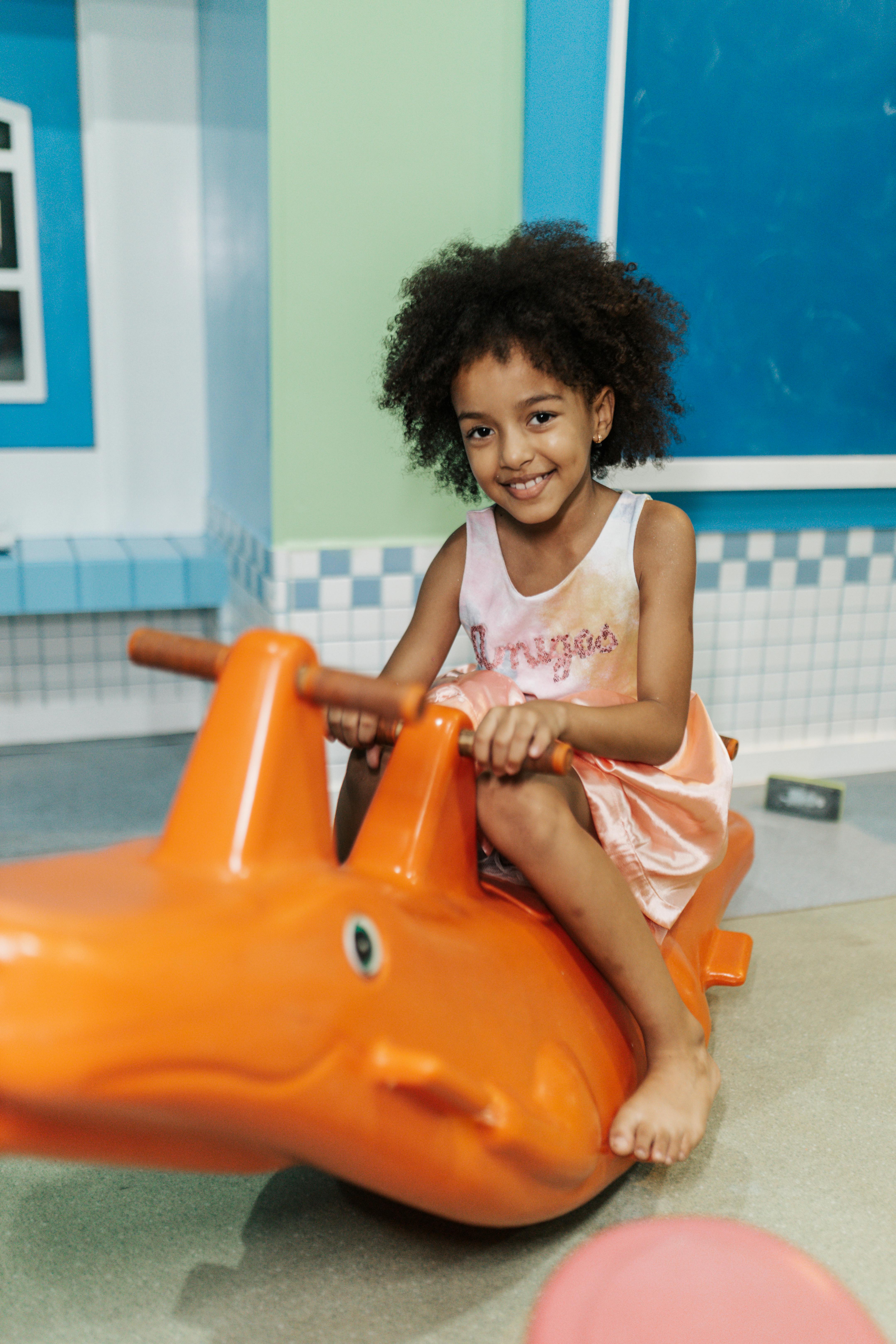 A Girl Sitting on a Toy · Free Stock Photo