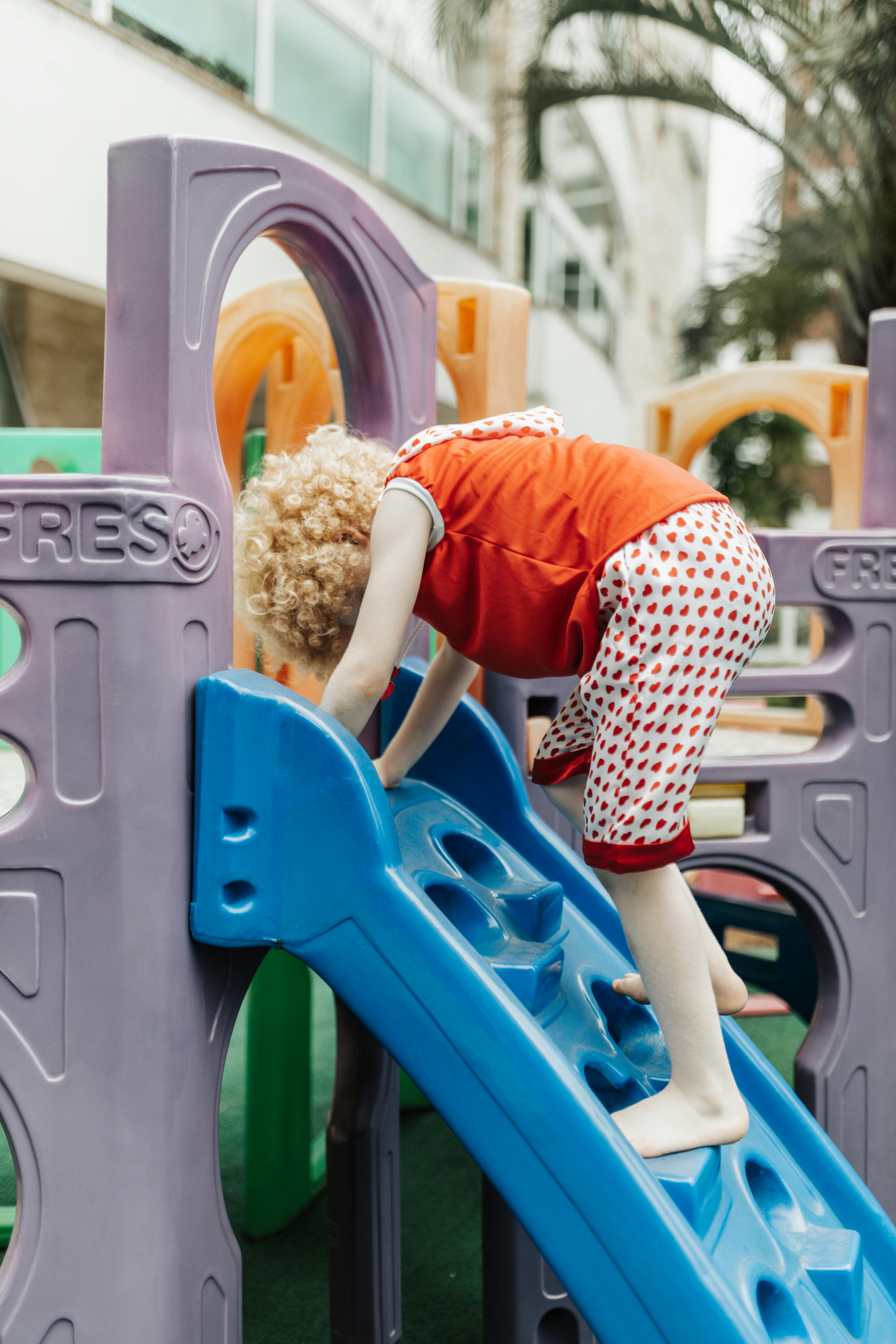 Young Boy Standing on a Slide · Free Stock Photo