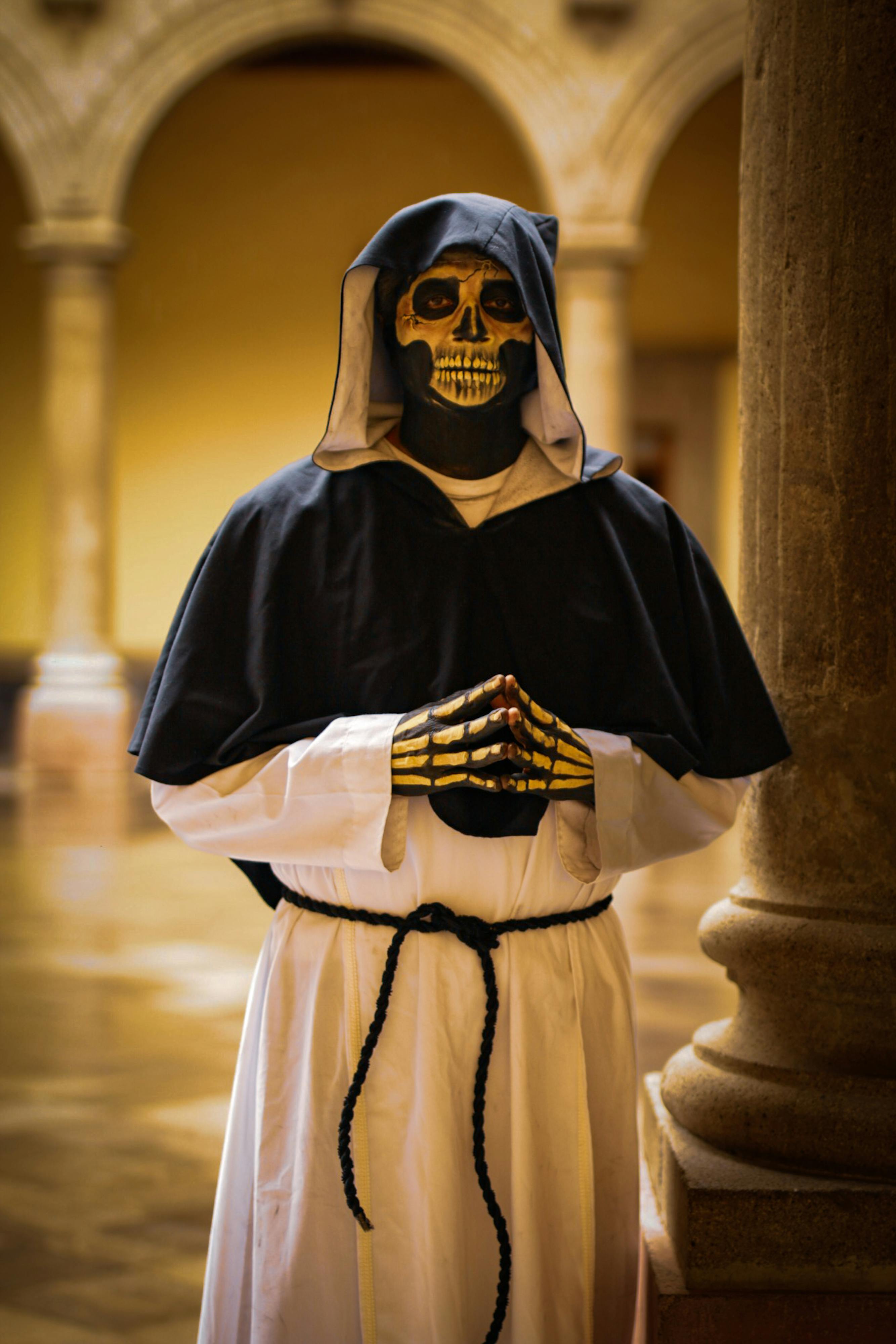 A man dressed as a skeleton in a black robe · Free Stock Photo