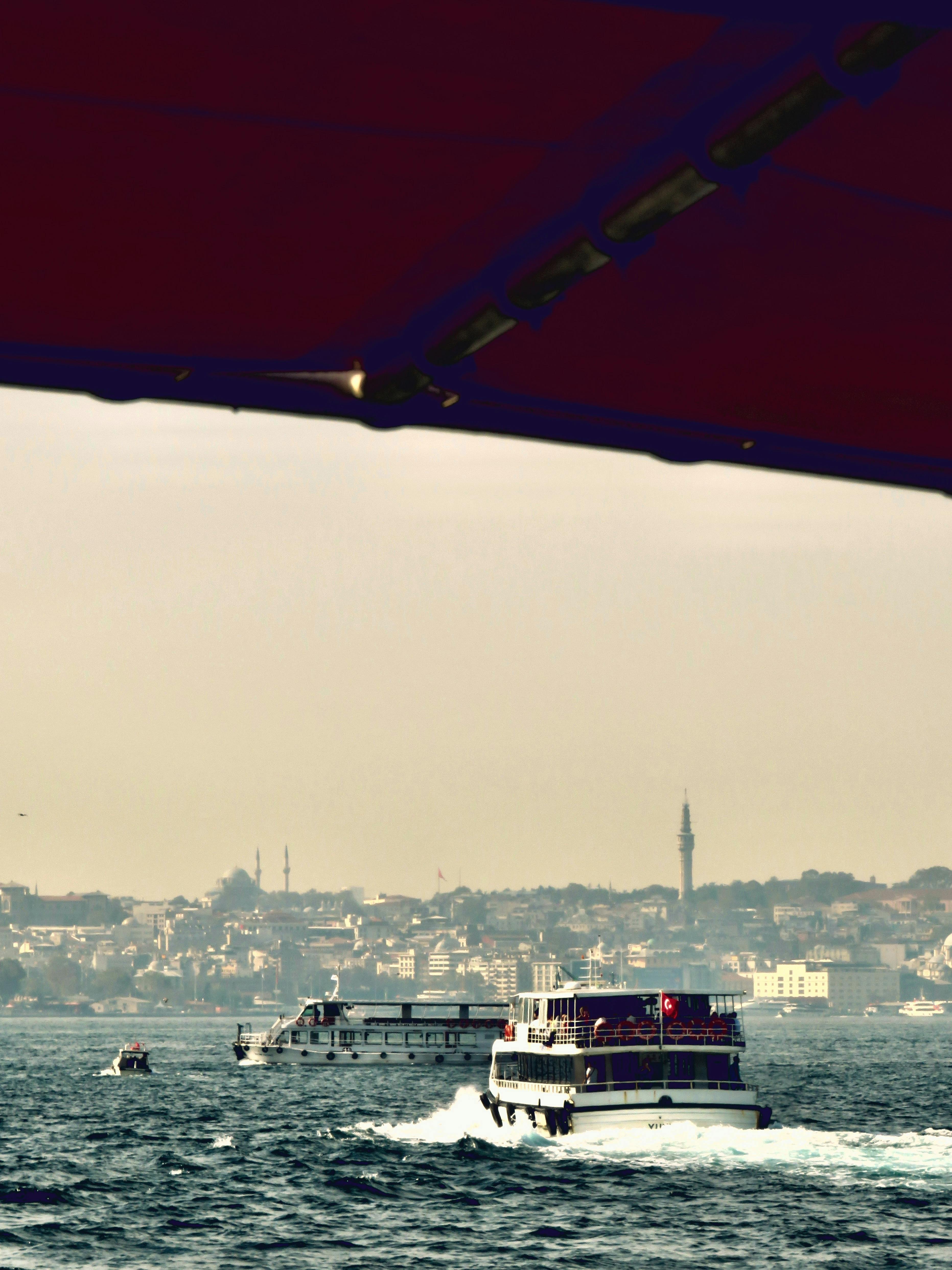 Ferry Boat Sailing under a Bridge in Bosporus Strait · Free Stock Photo