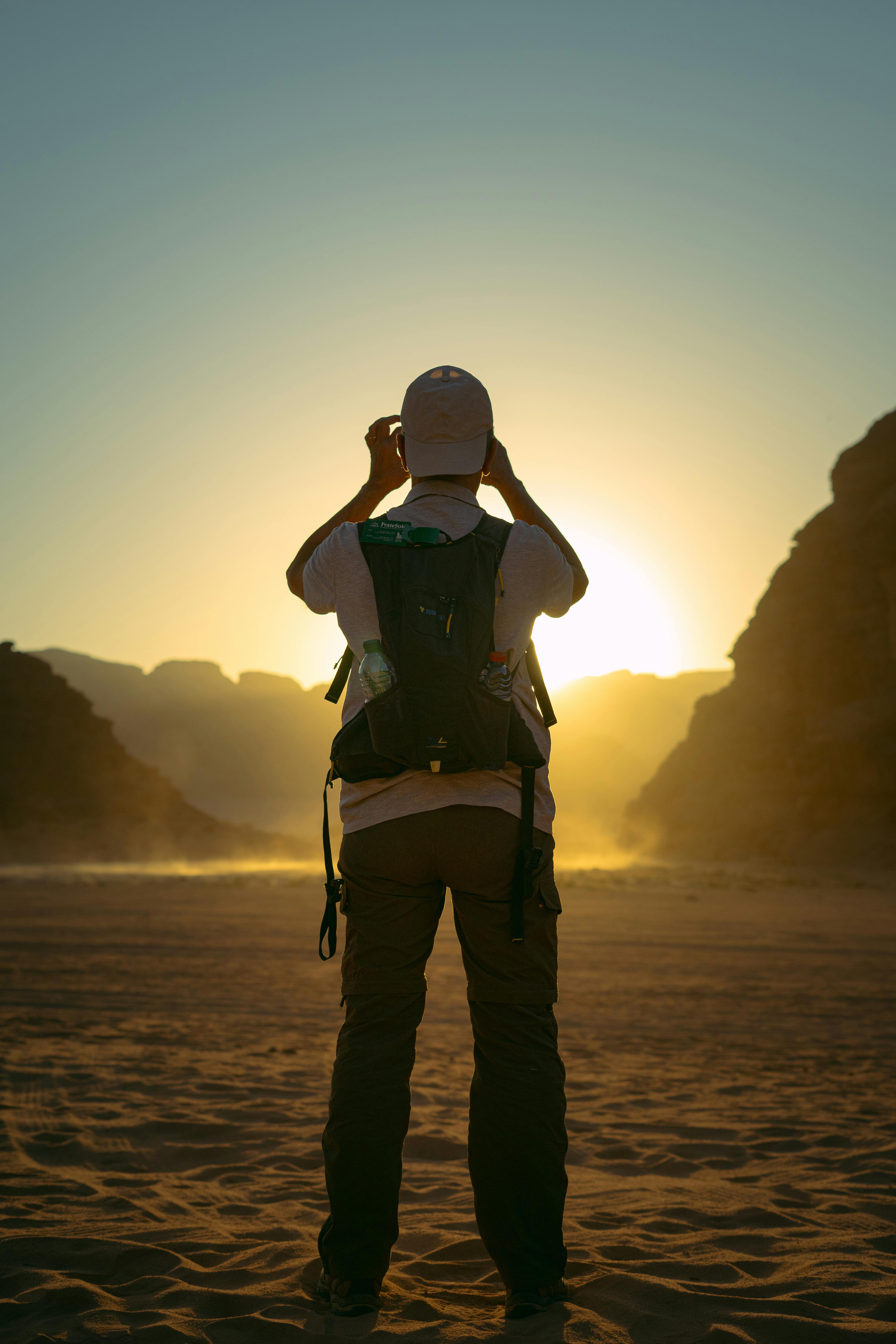Back View of Man Hiking on Desert at Sunset · Free Stock Photo