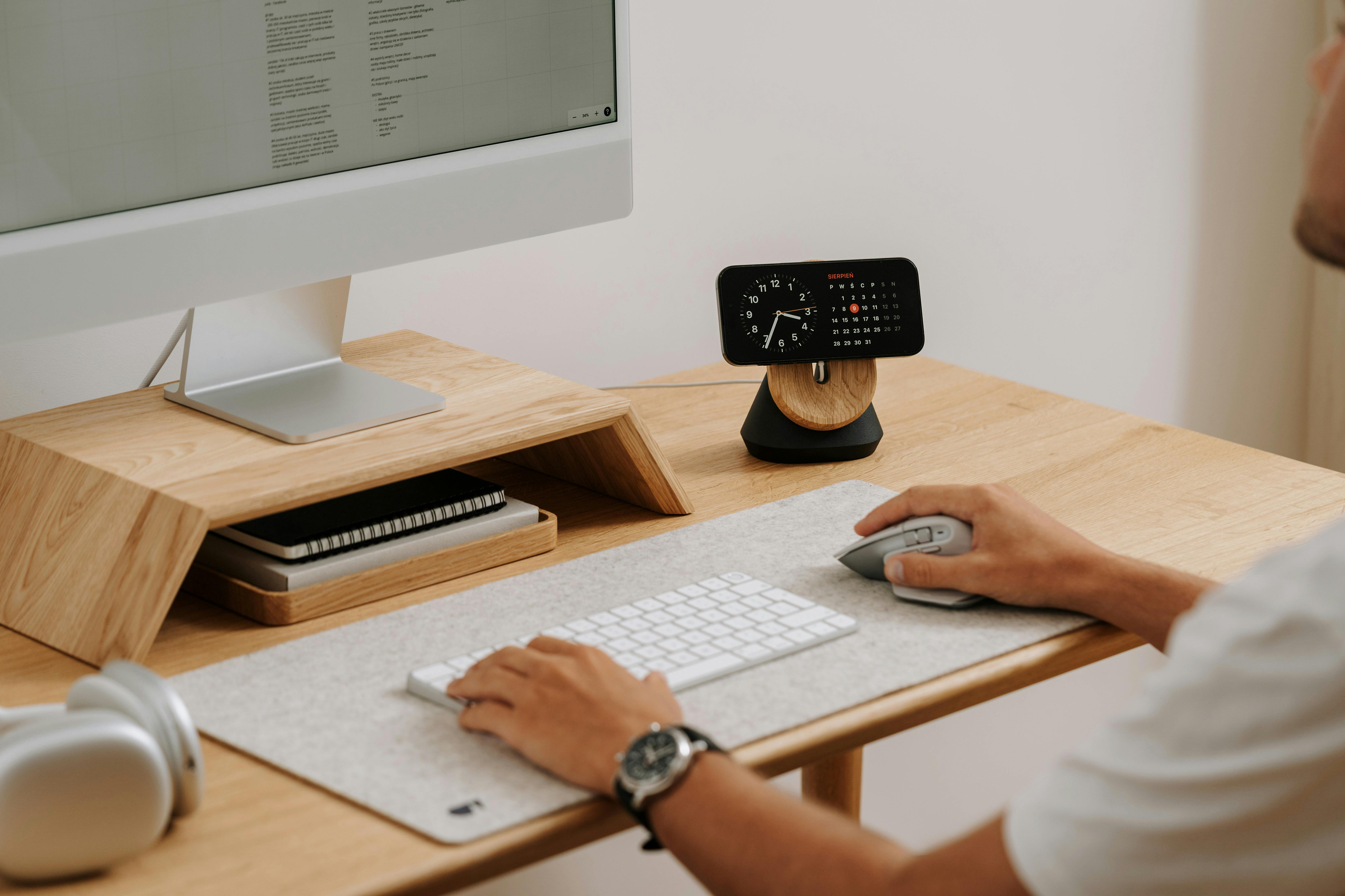 A man is sitting at a desk with a computer monitor · Free Stock Photo