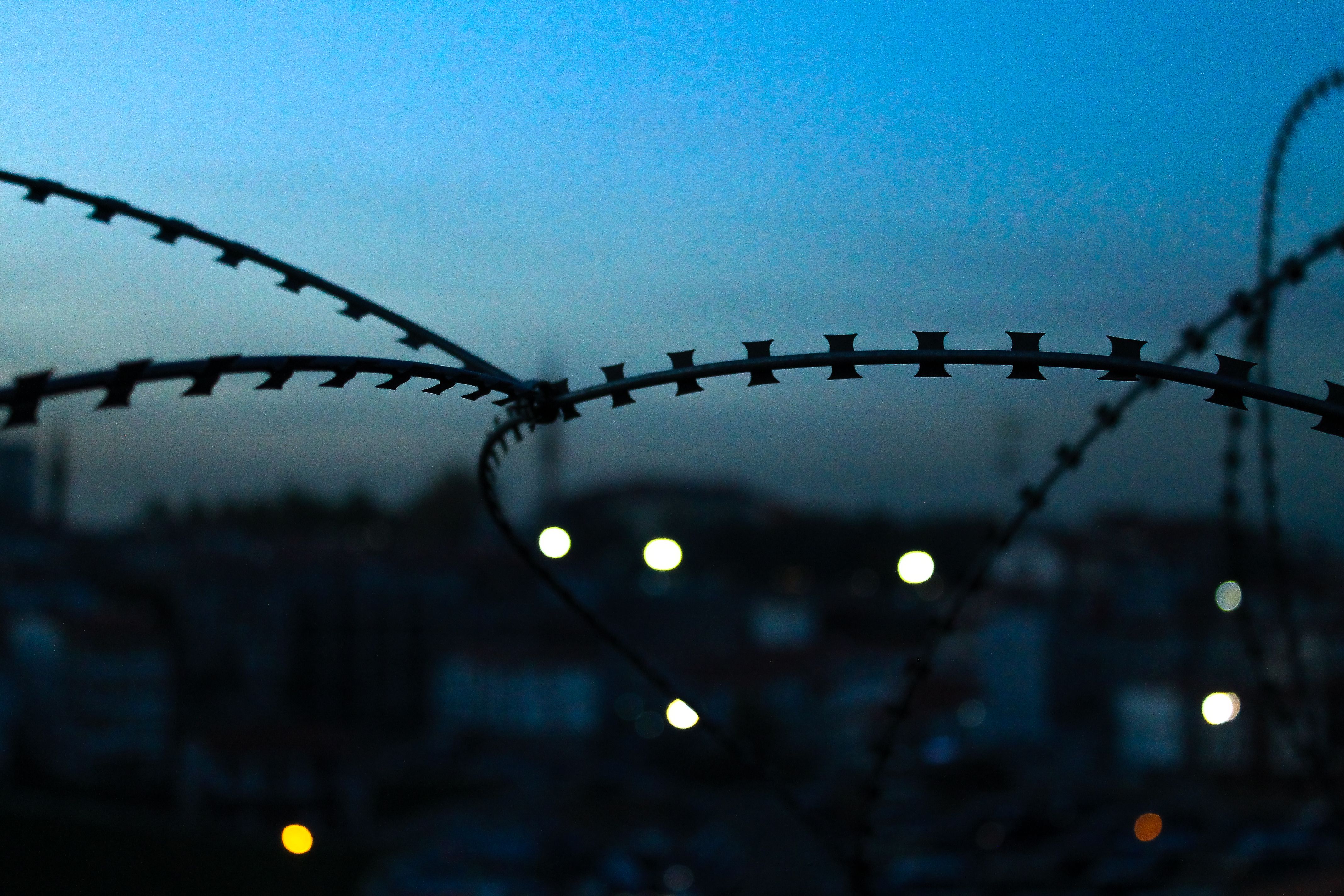 Photo gratuite de aube, barrière, bokeh, crépuscule, fil barbelé, sombre