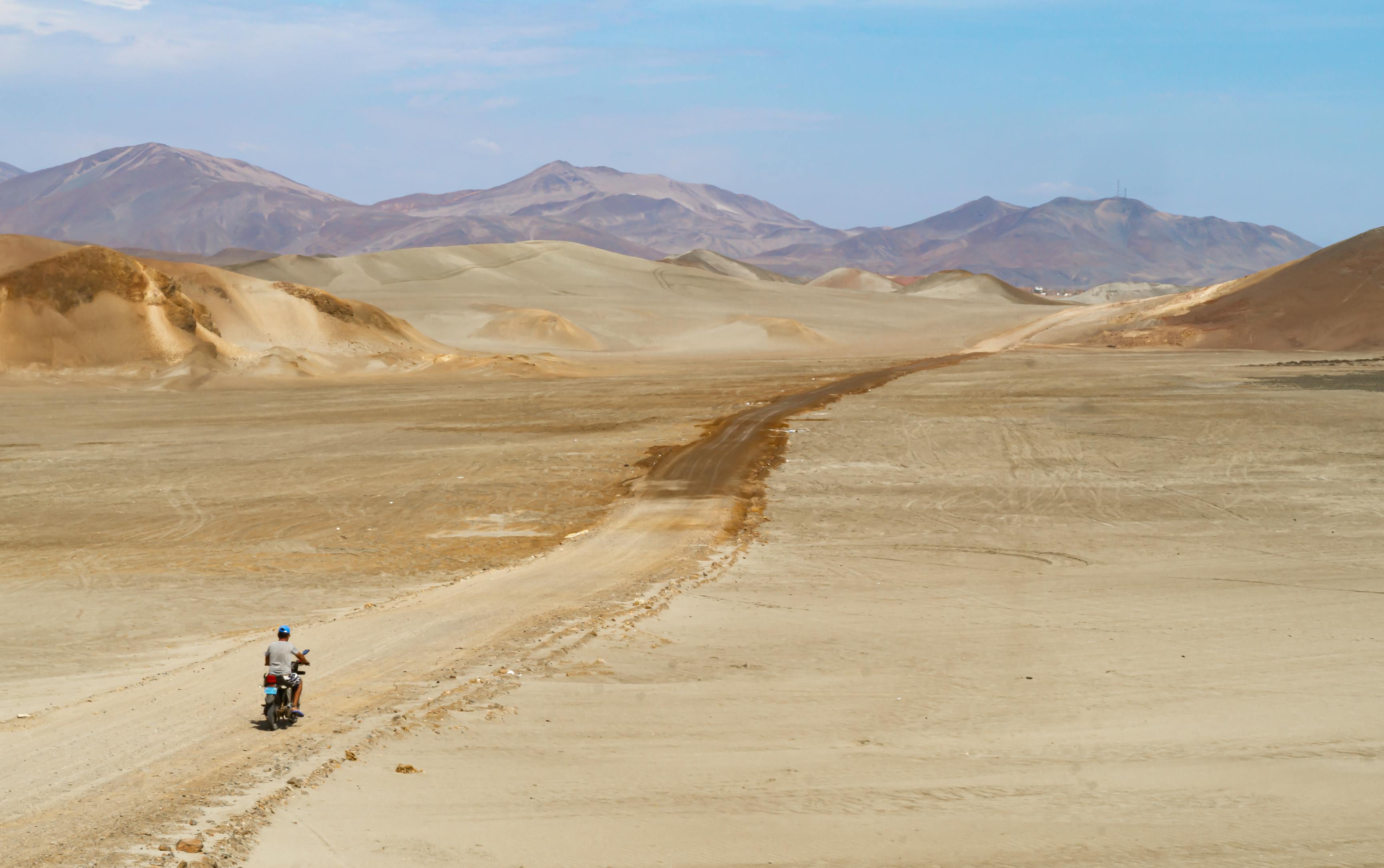 Man Riding a Bike on a Road on a Desert · Free Stock Photo