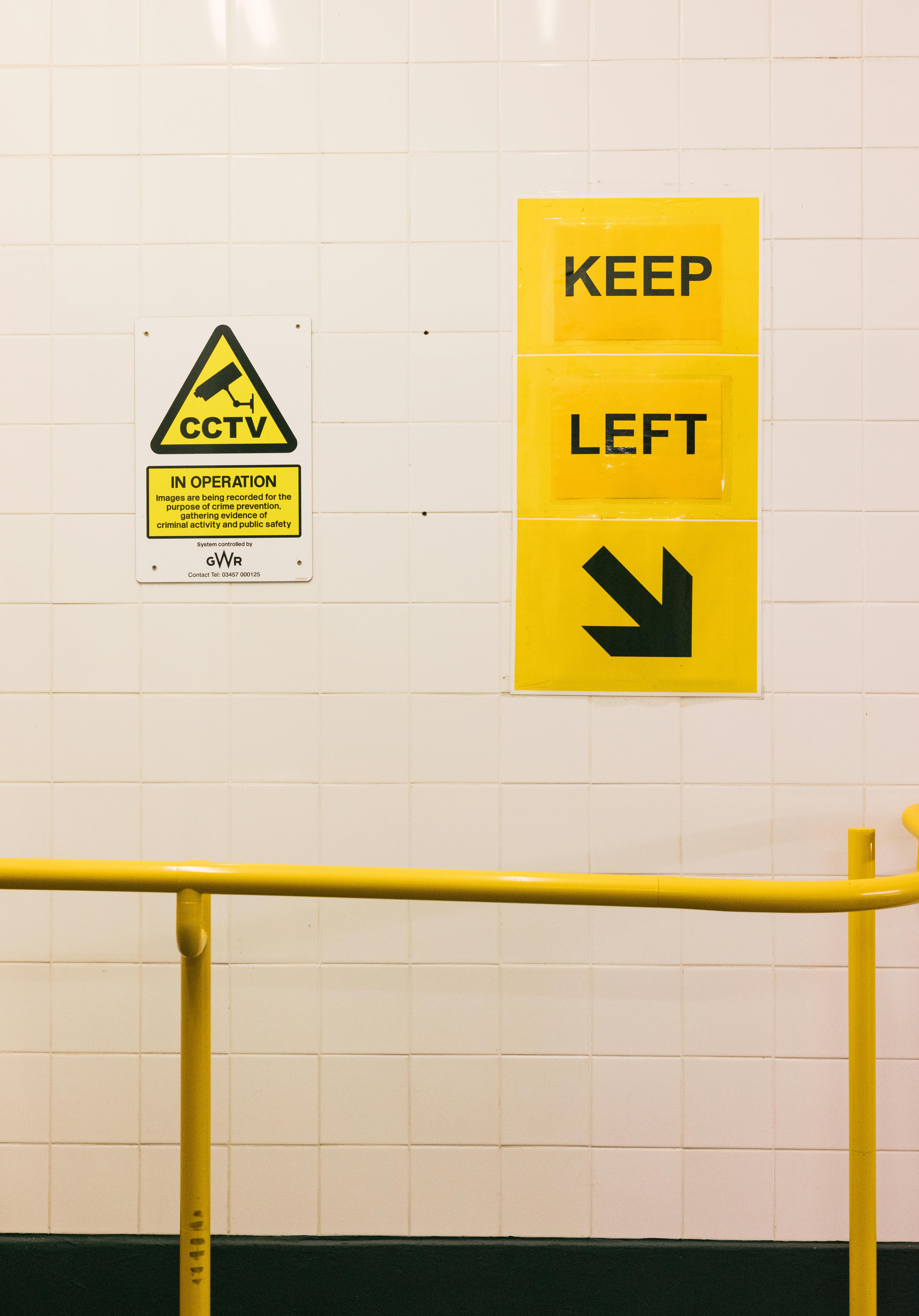 Information Signs on a Wall above a Yellow Railing · Free Stock Photo