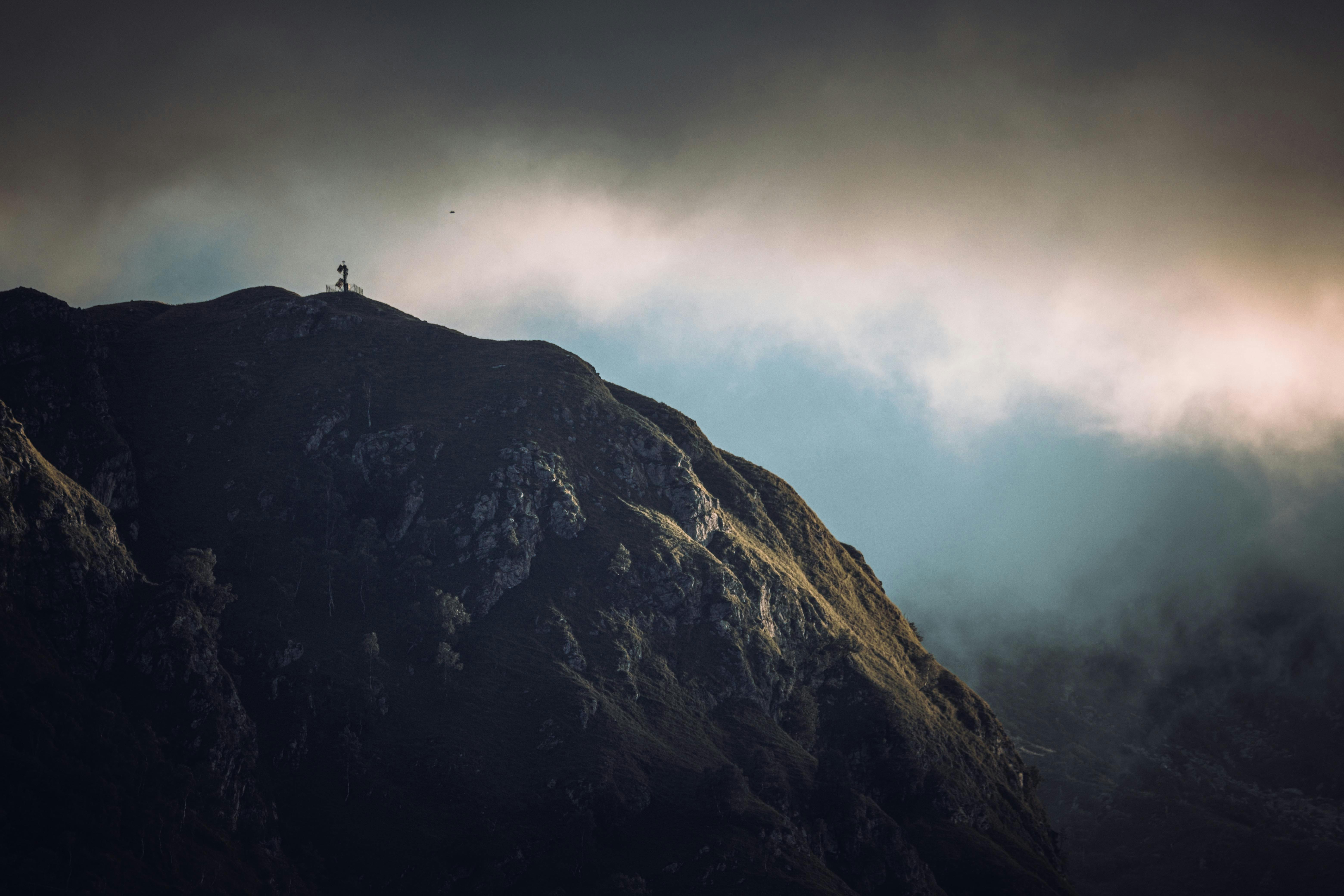 View of a Dark Rocky Mountain under a Cloudy Sky · Free Stock Photo