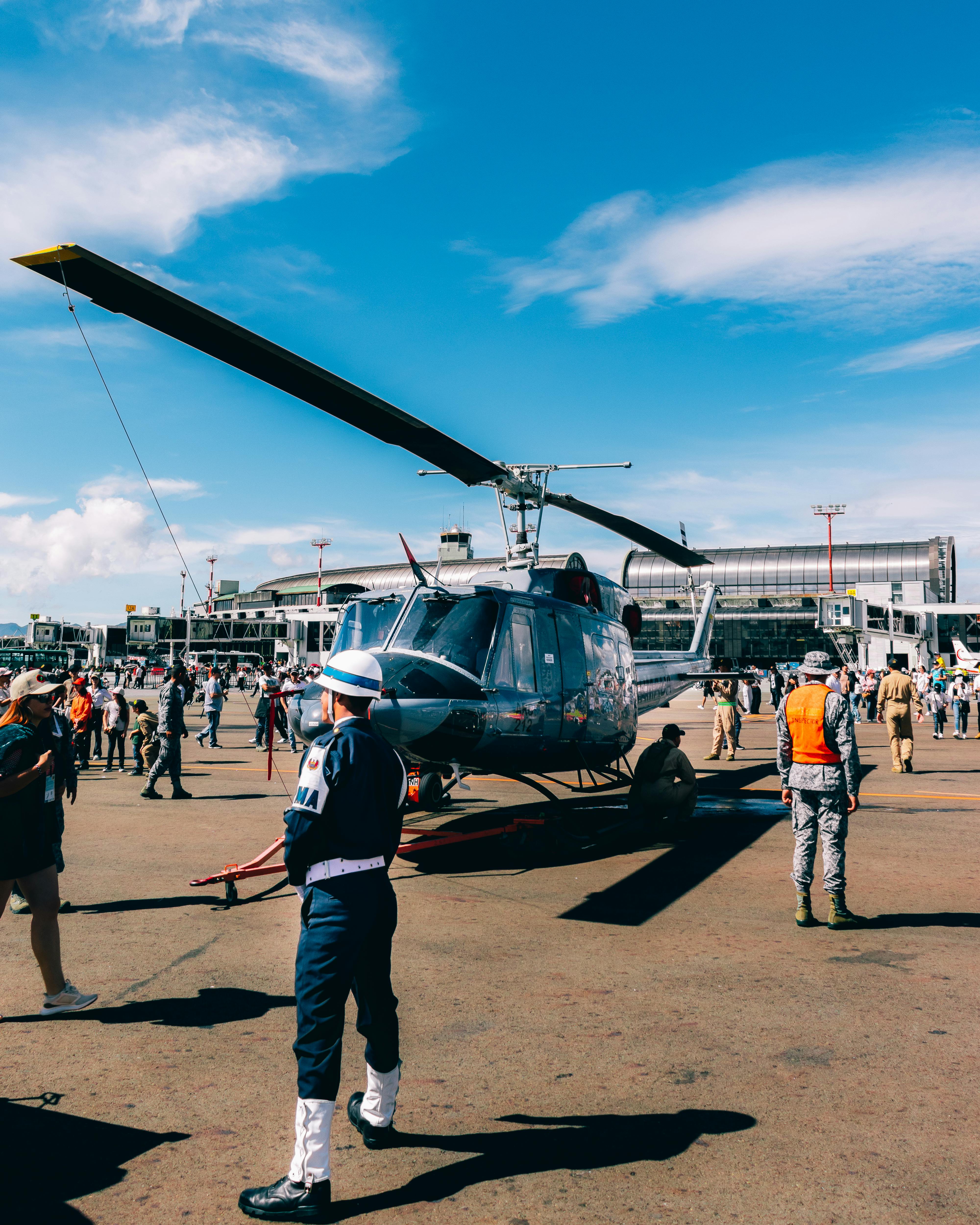 A Crowd Walking around a Military Helicopter · Free Stock Photo