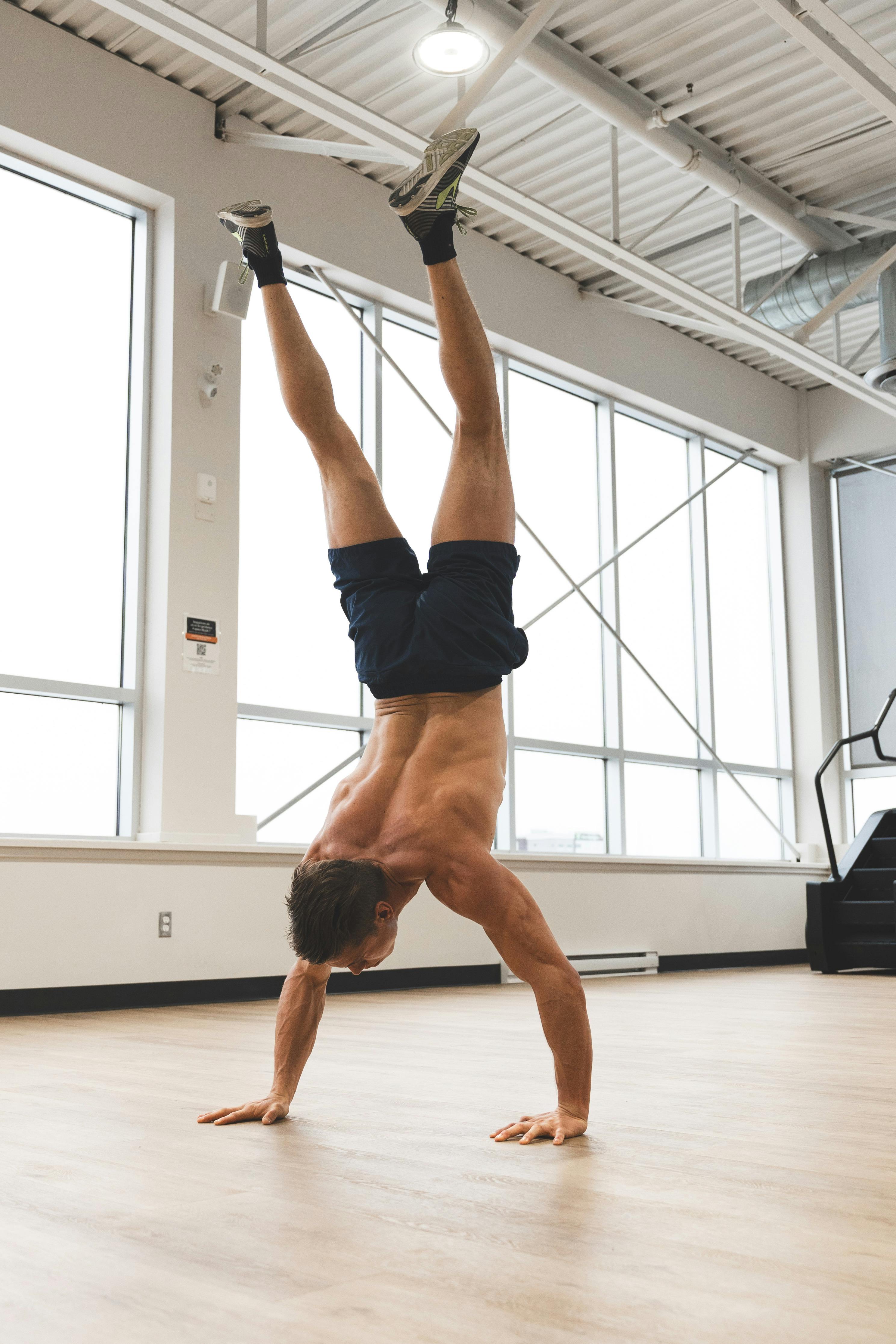 Muscular Shirtless Man Doing a Handstand · Free Stock Photo