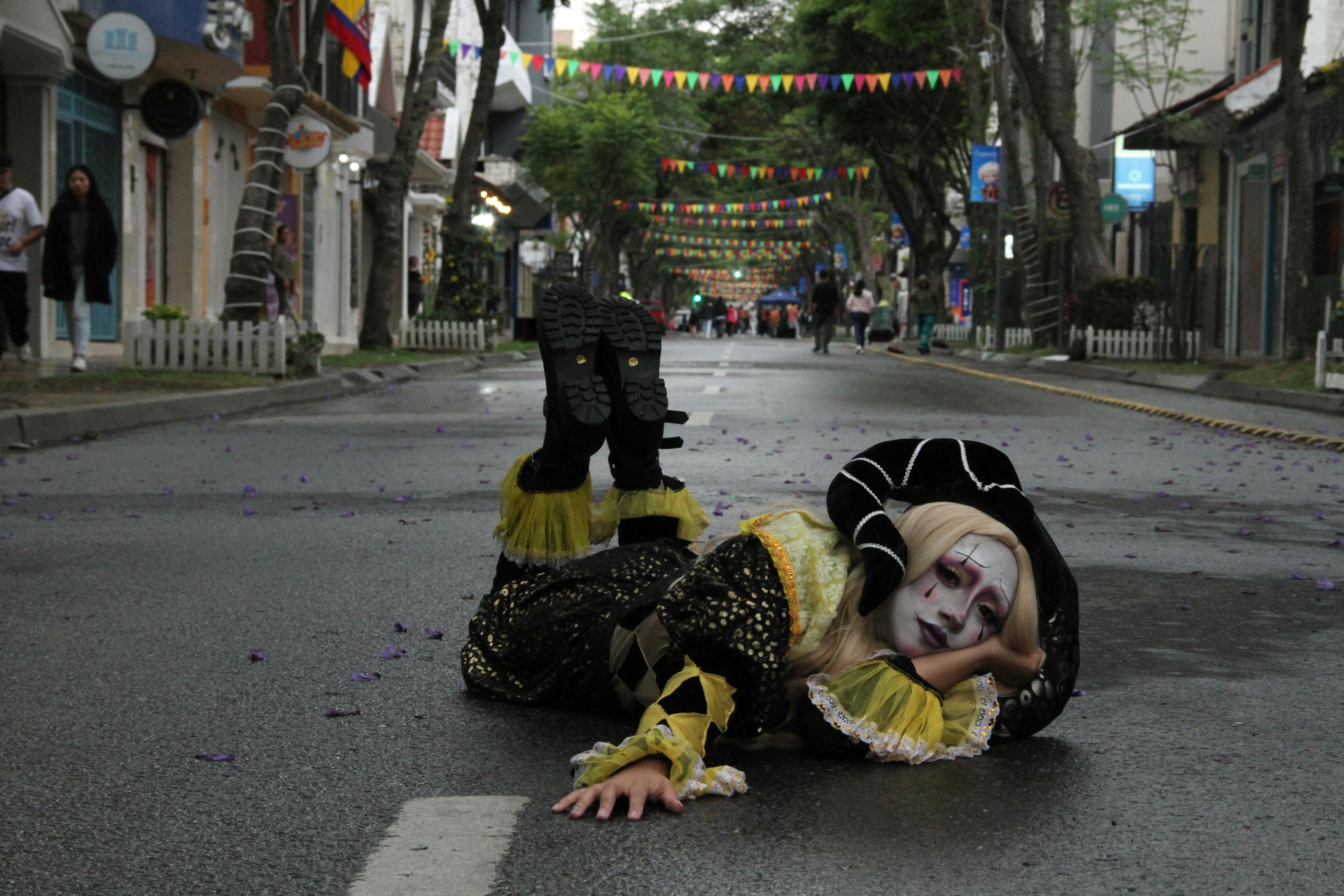 A Dressed Up Clown Lying on a City Street · Free Stock Photo
