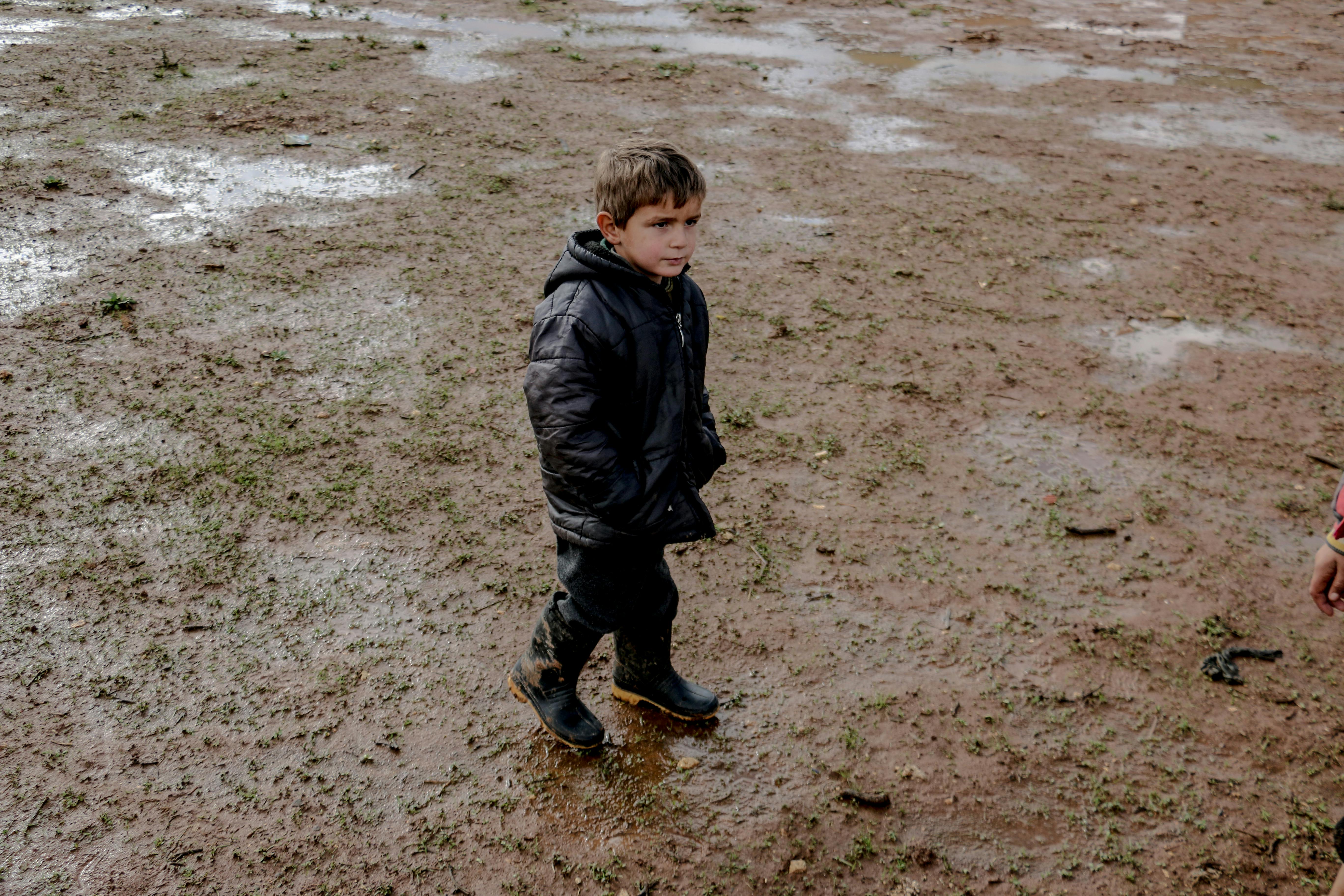 Person helping ethnic boy getting out of mud · Free Stock Photo