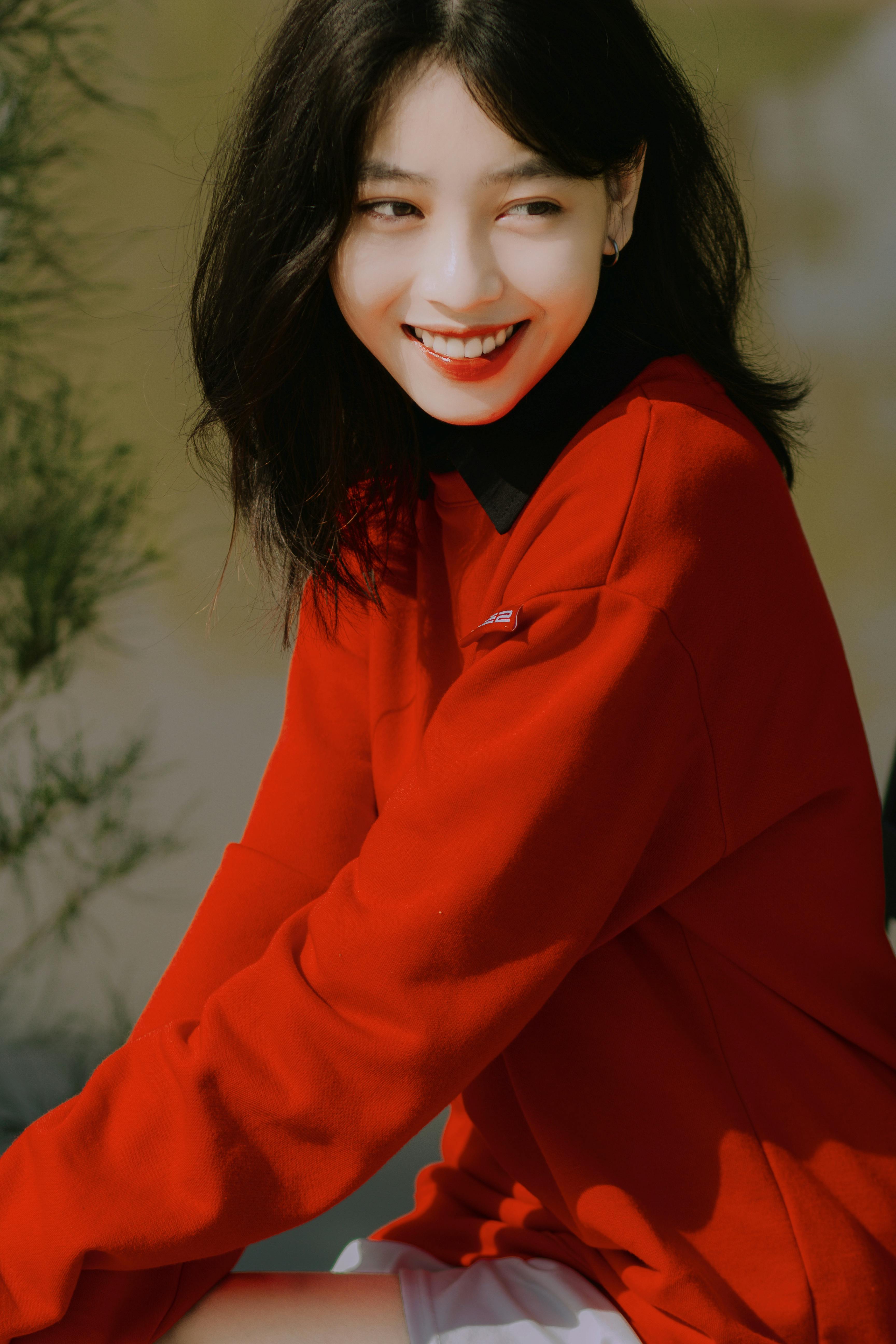 Young Woman in a Red Sweatshirt and White Shorts · Free Stock Photo