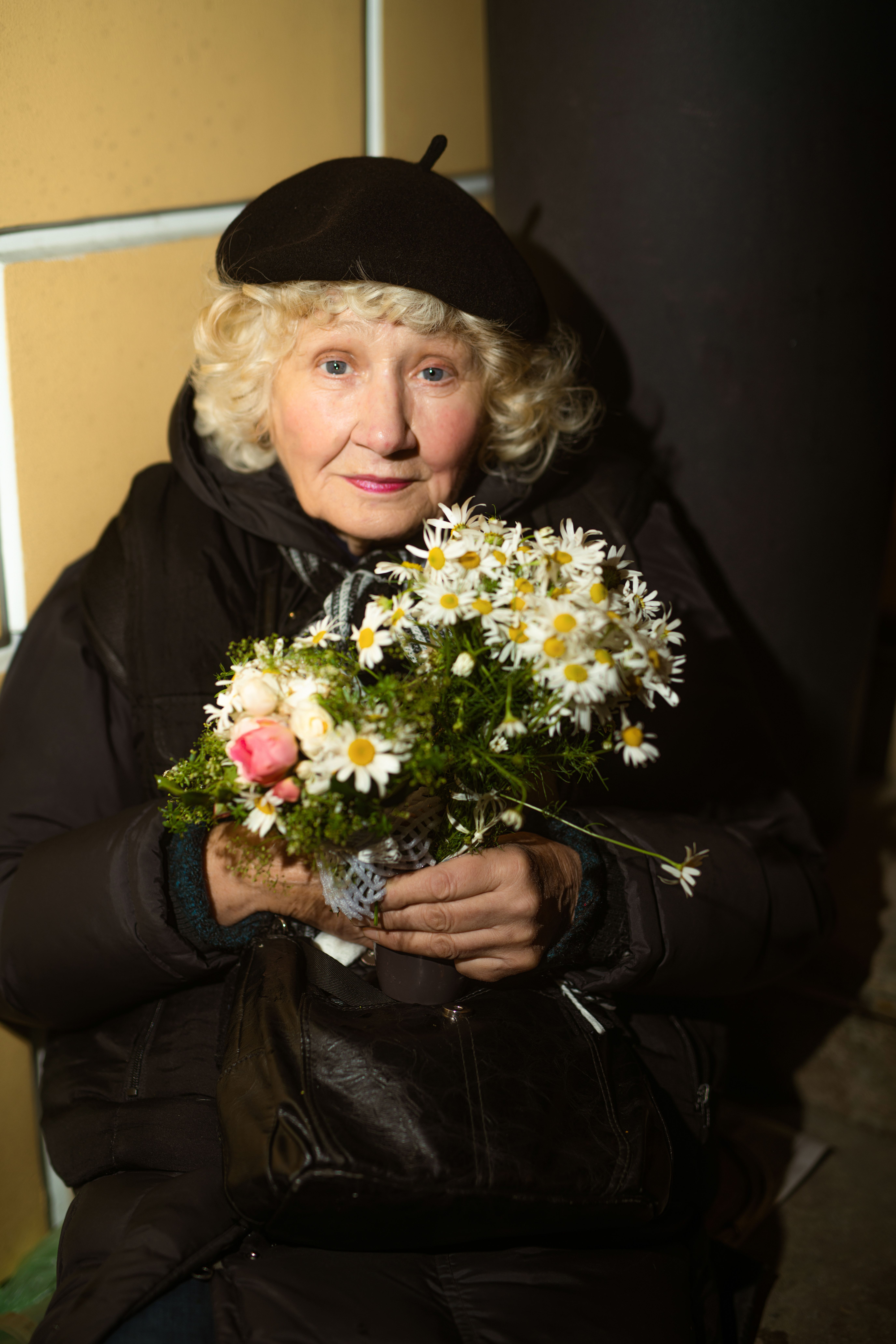 Elegant Elderly Woman Holding a Bunch of Flowers · Free Stock Photo