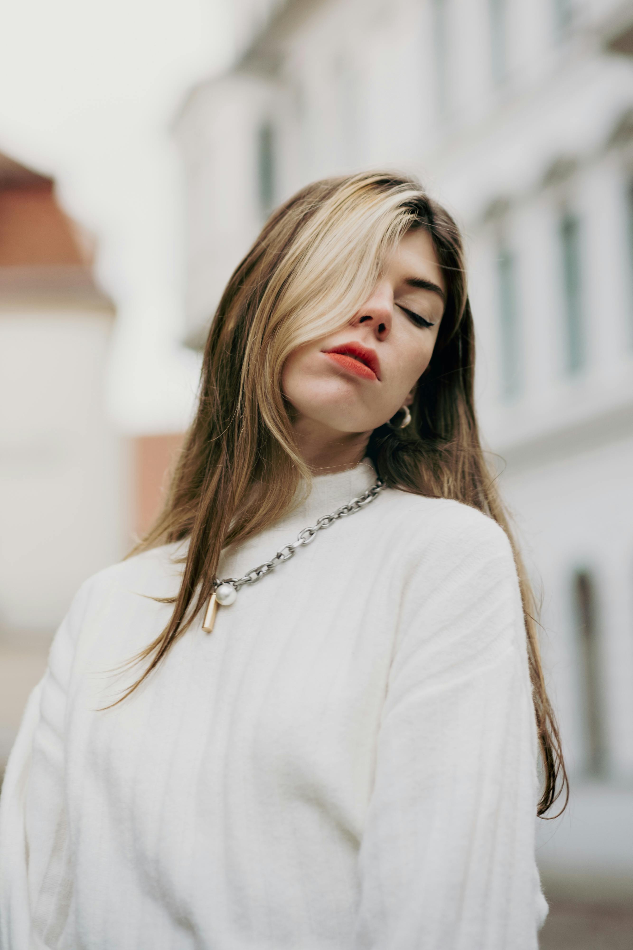 Model Wearing a White Sweater, Posing in a Town · Free Stock Photo