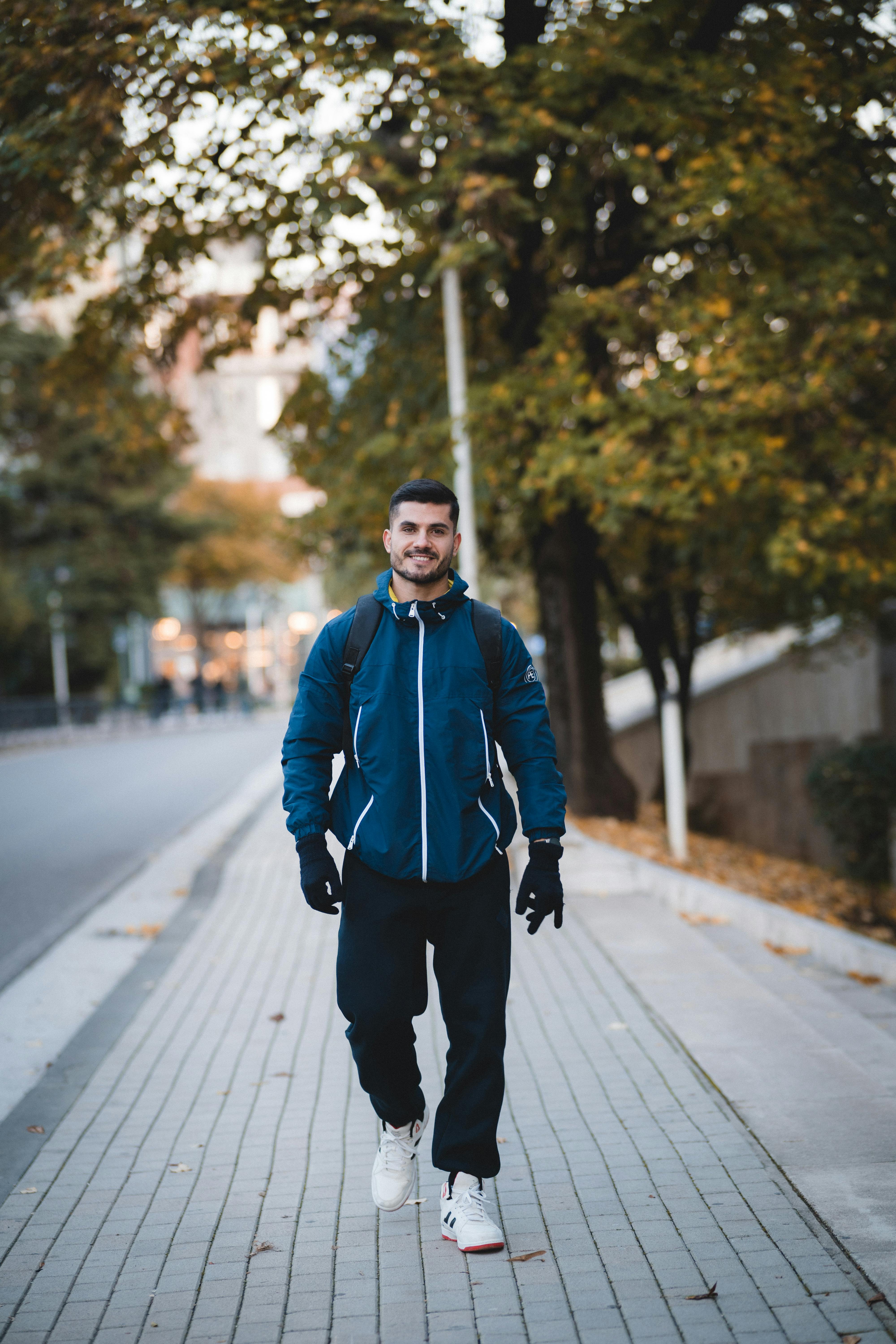 Young Man Walking on the Sidewalk in City and Smiling · Free Stock Photo